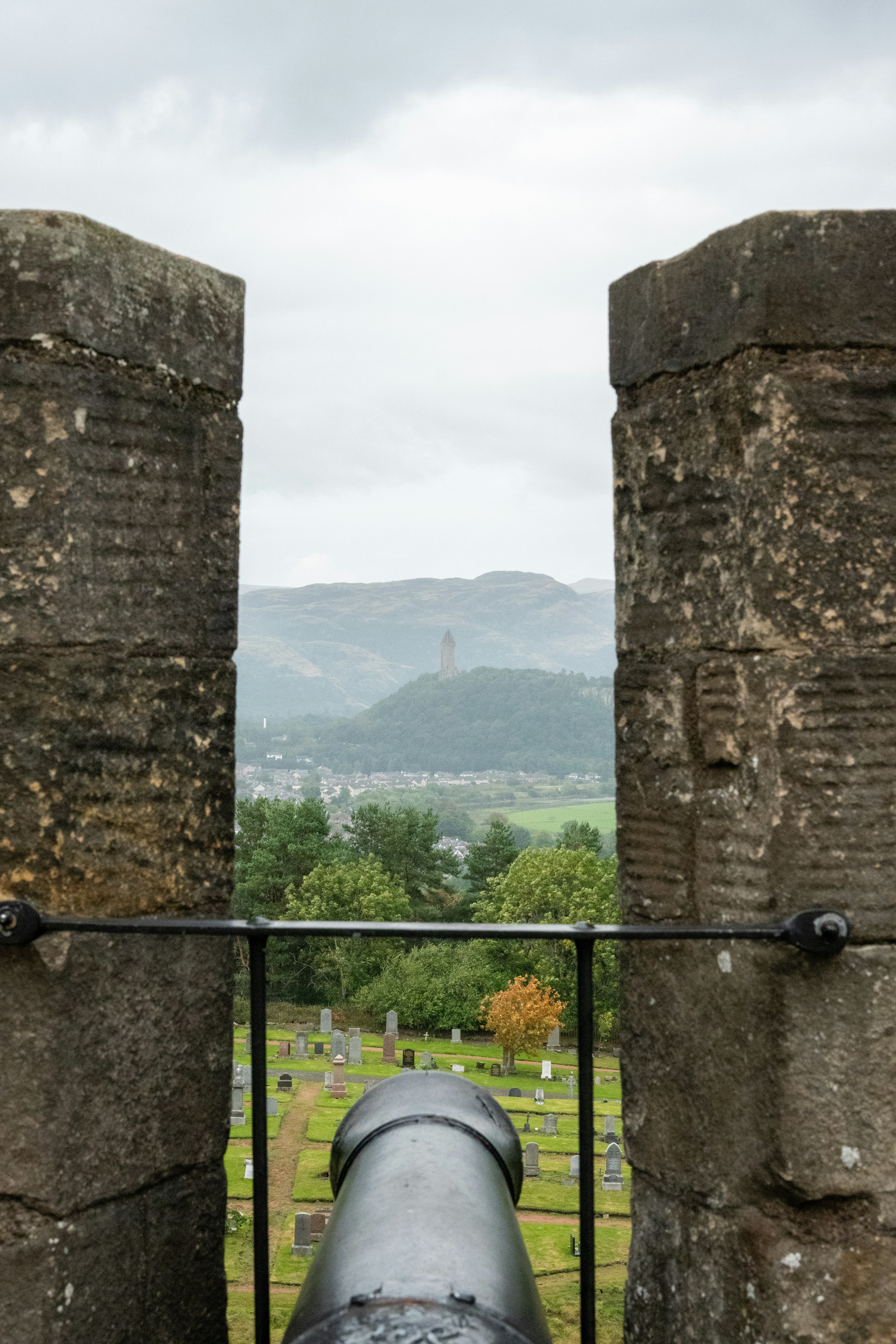 Through the Gate: A Cemetery Vista Framed by Ancient Battlements