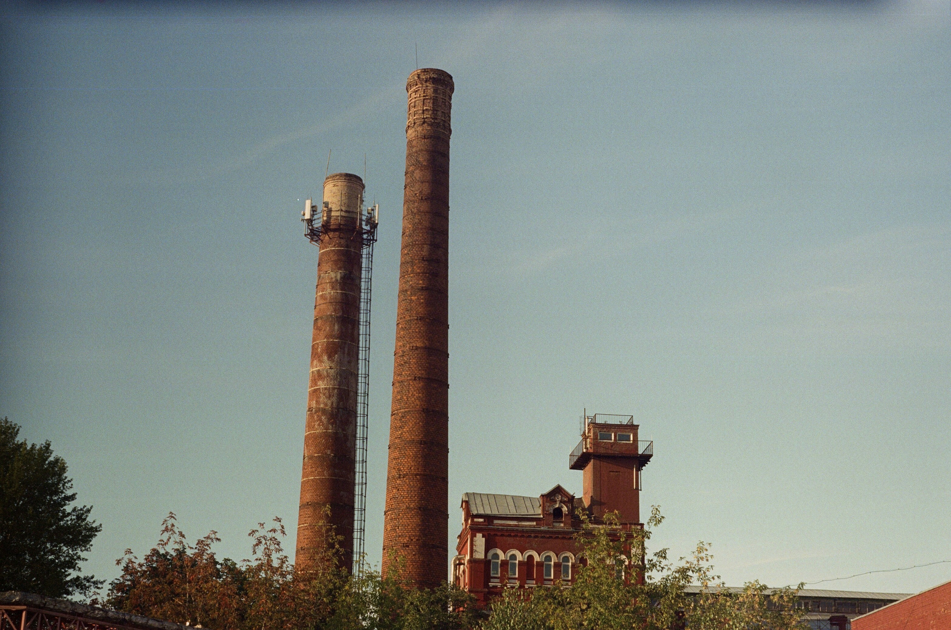 Industrial Sentinels: Two towering chimneys against a tranquil sky