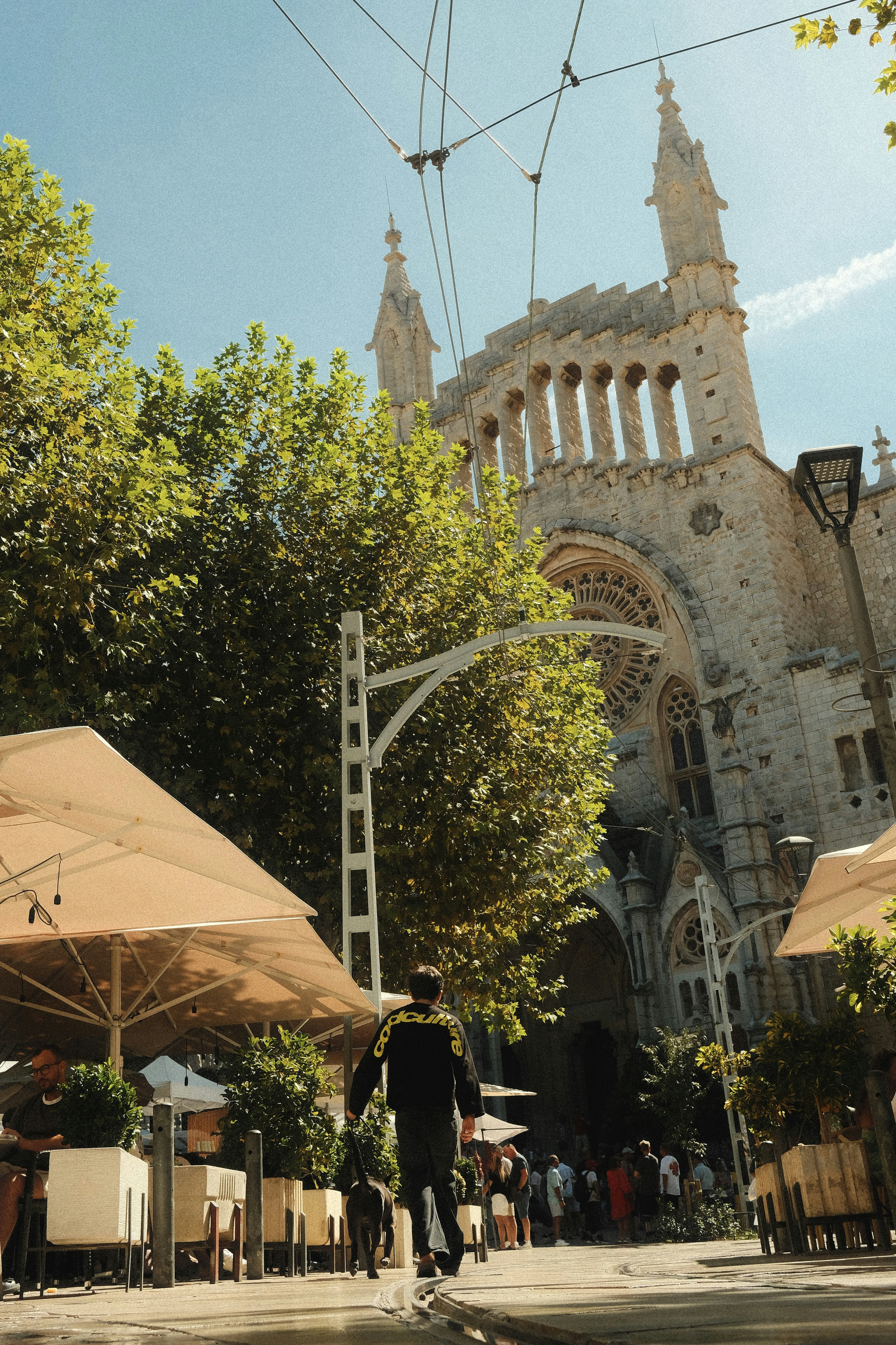 Stone Cathedral Awash in Sunlight: A Pedestrian Path beneath Towering Turrets