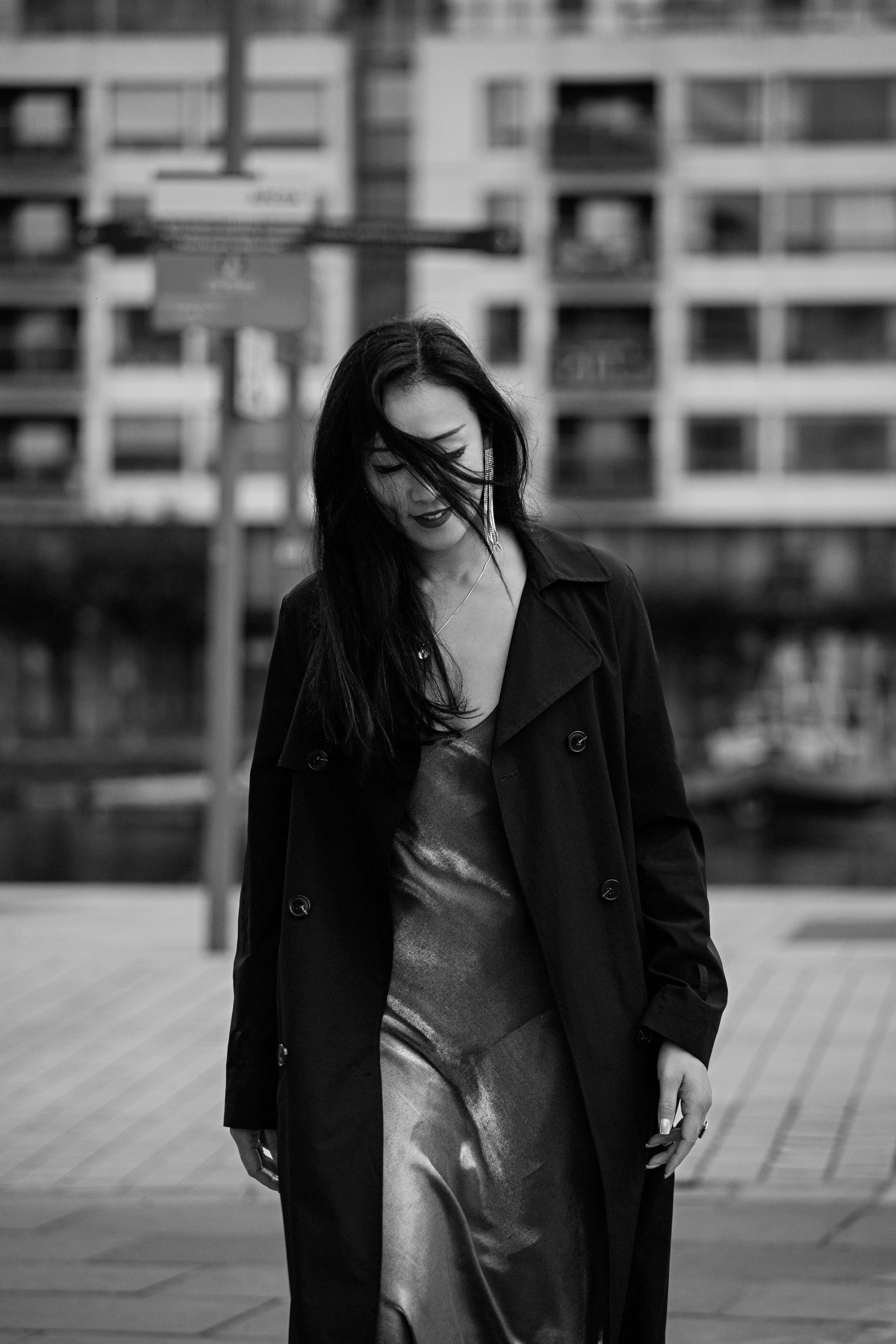 Urban Silhouette: A Woman in a Long Coat Undercity Facade