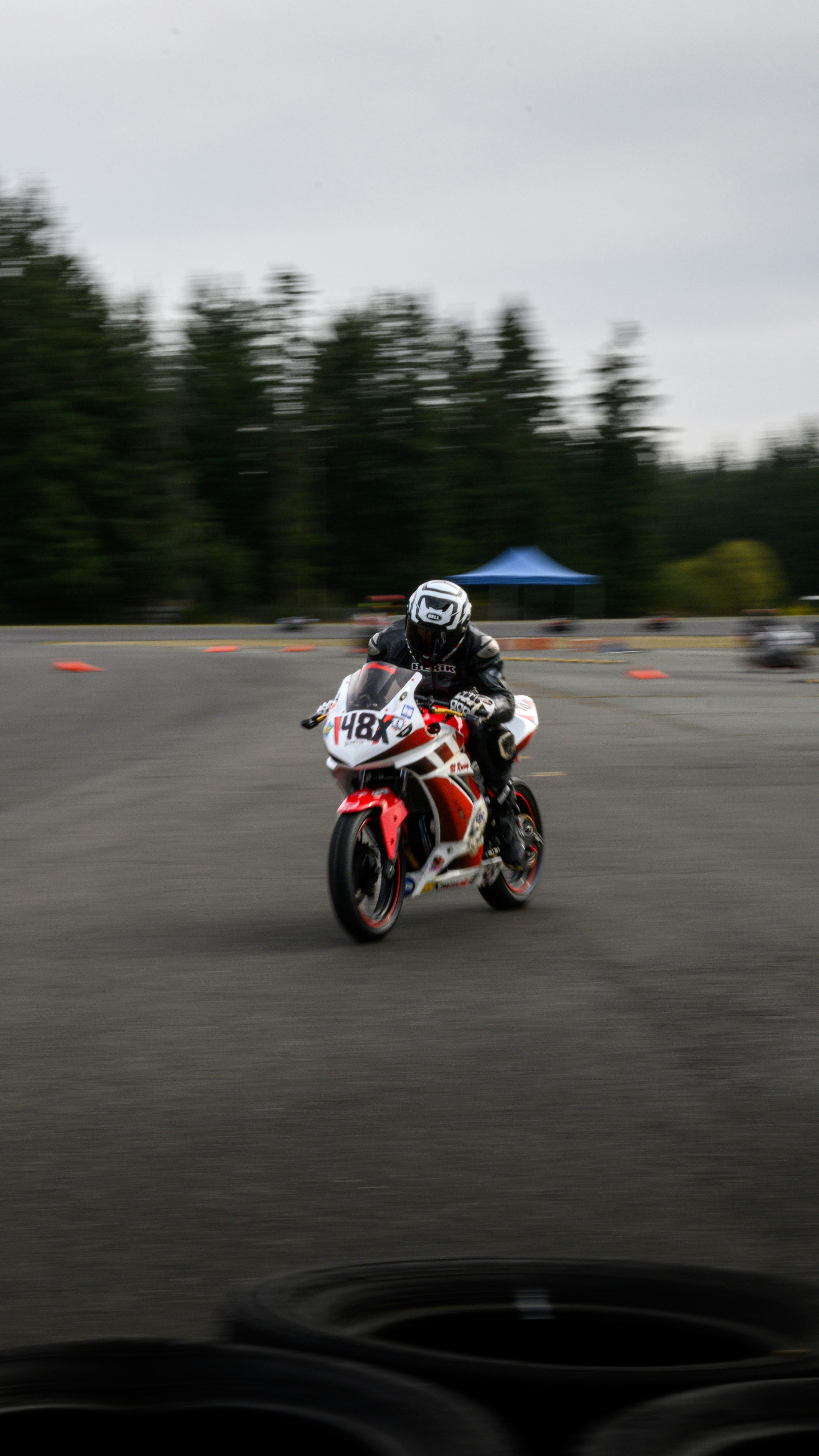 Racing through the Rain: A Rider in Focus on a Blurred Asphalt Track