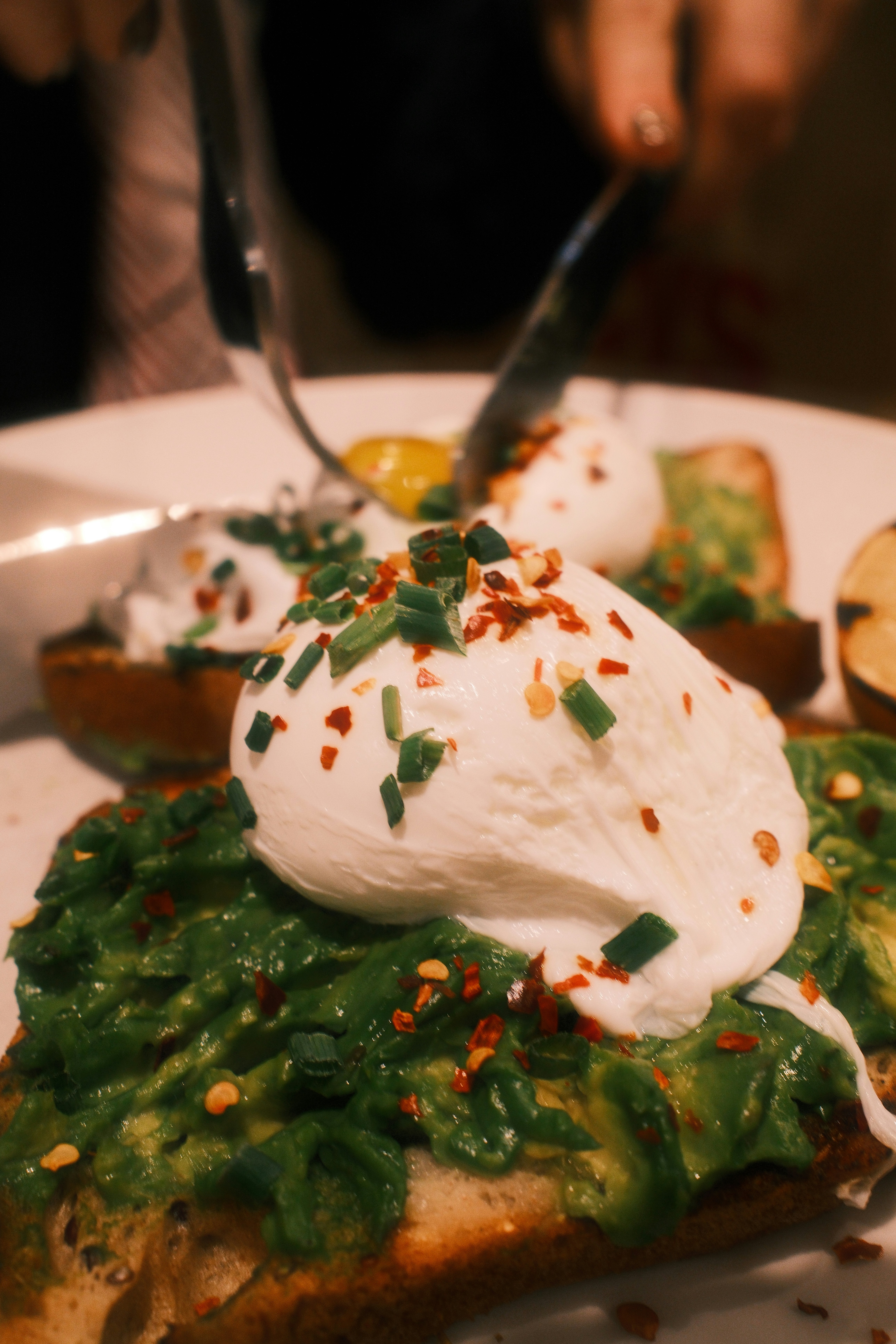 Creamy Poached Eggs on Avocado Toast Beneath a Pepper-Red Pepper Dust