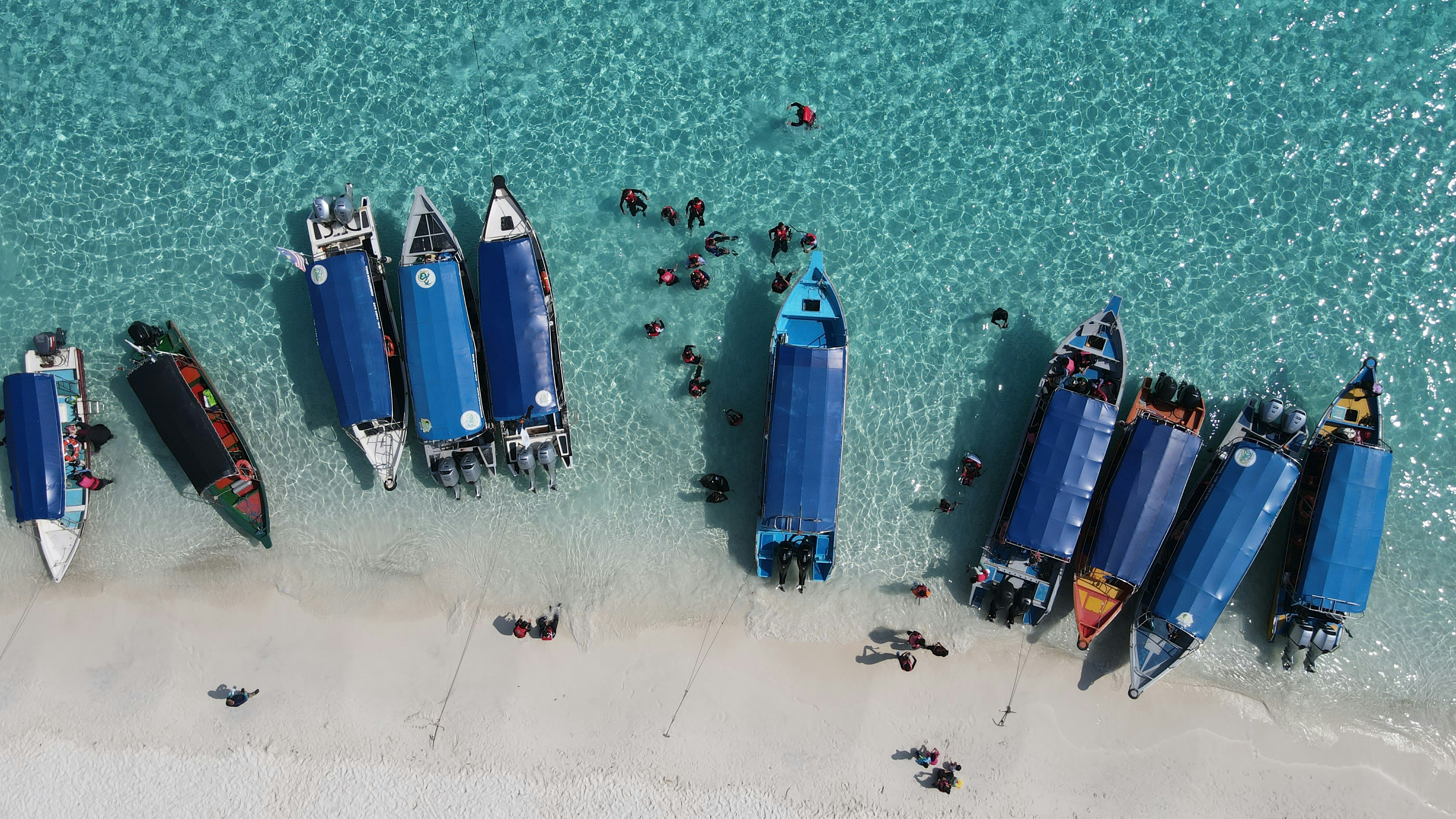 Azure Fleet: Colorful Boats Rest Along a Turquoise Shore