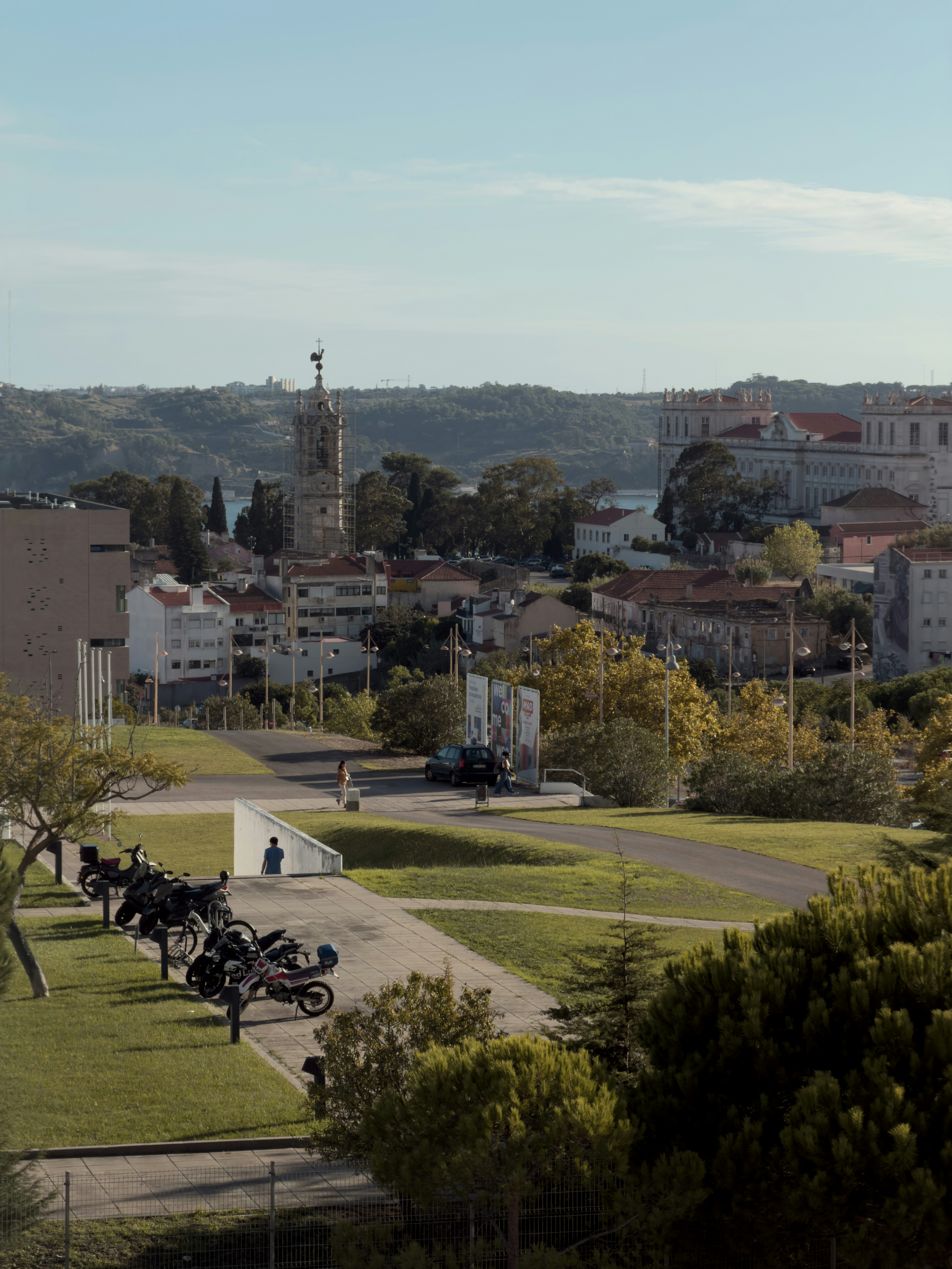 Sunlit hillside panorama with a quiet bicycle cluster and distant city core