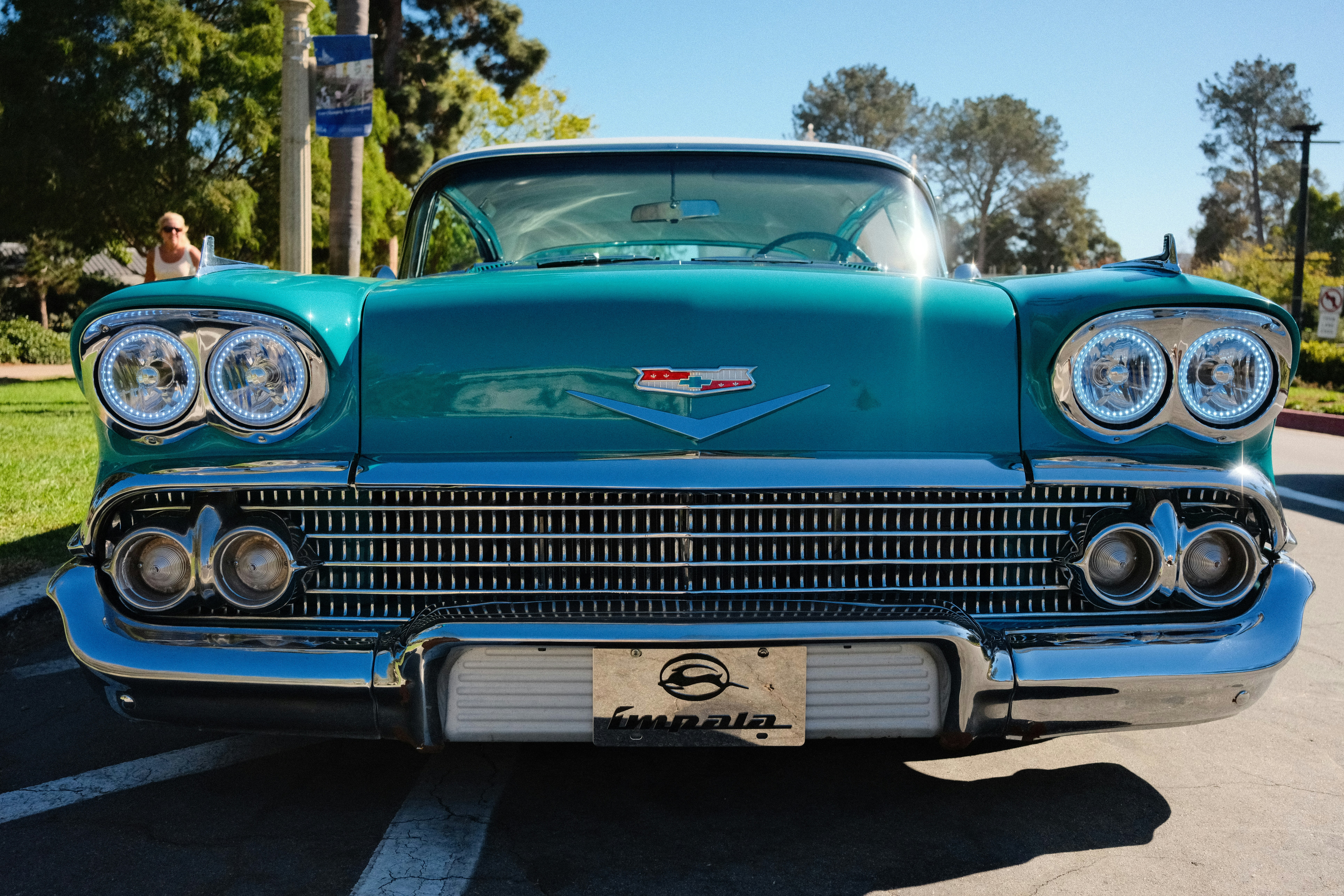 Turquoise Classic: A gleaming front end of a vintage Chevy on sunlit pavement