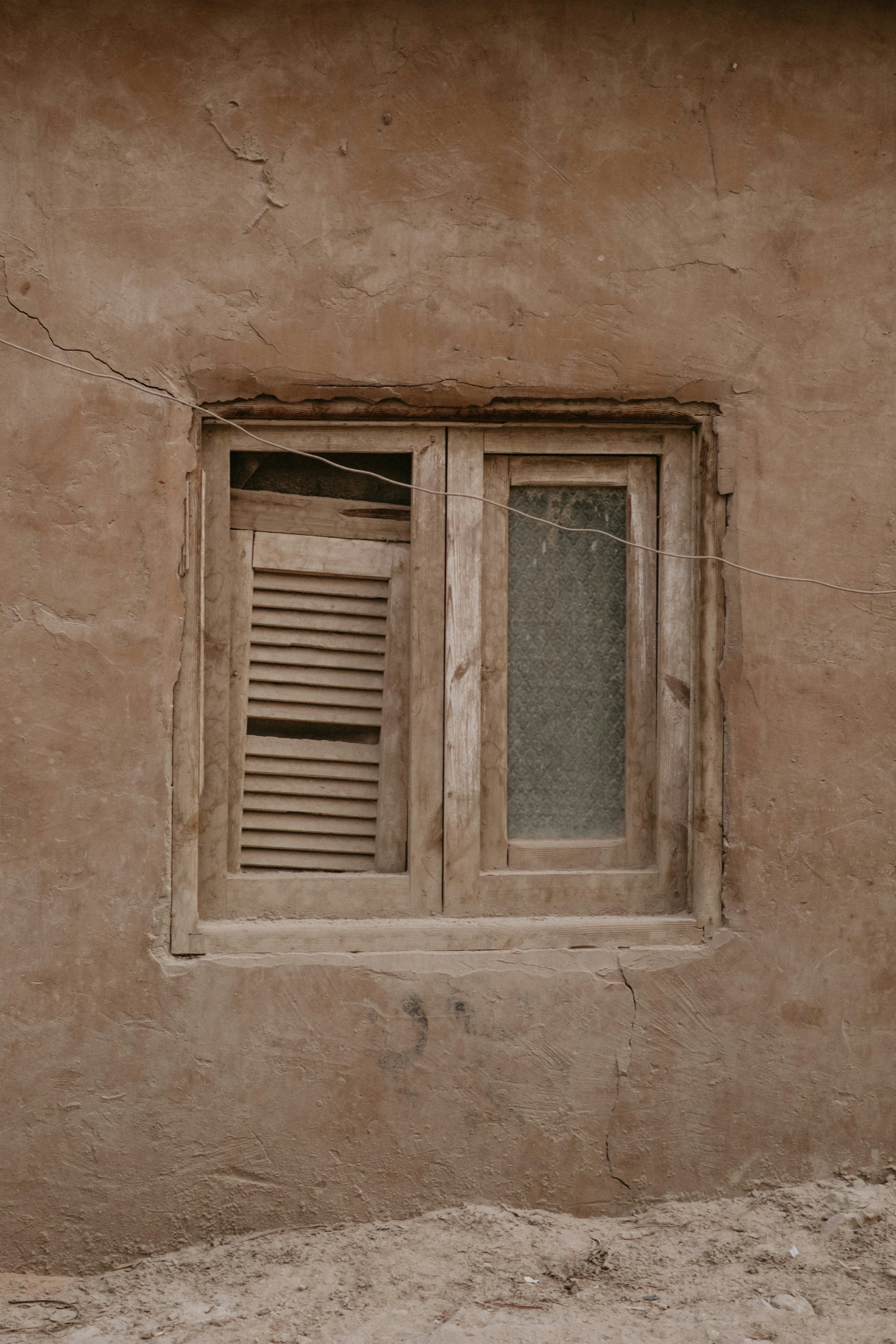 Weathered Windowed Wall: An Earthen Facade with Static Fractures