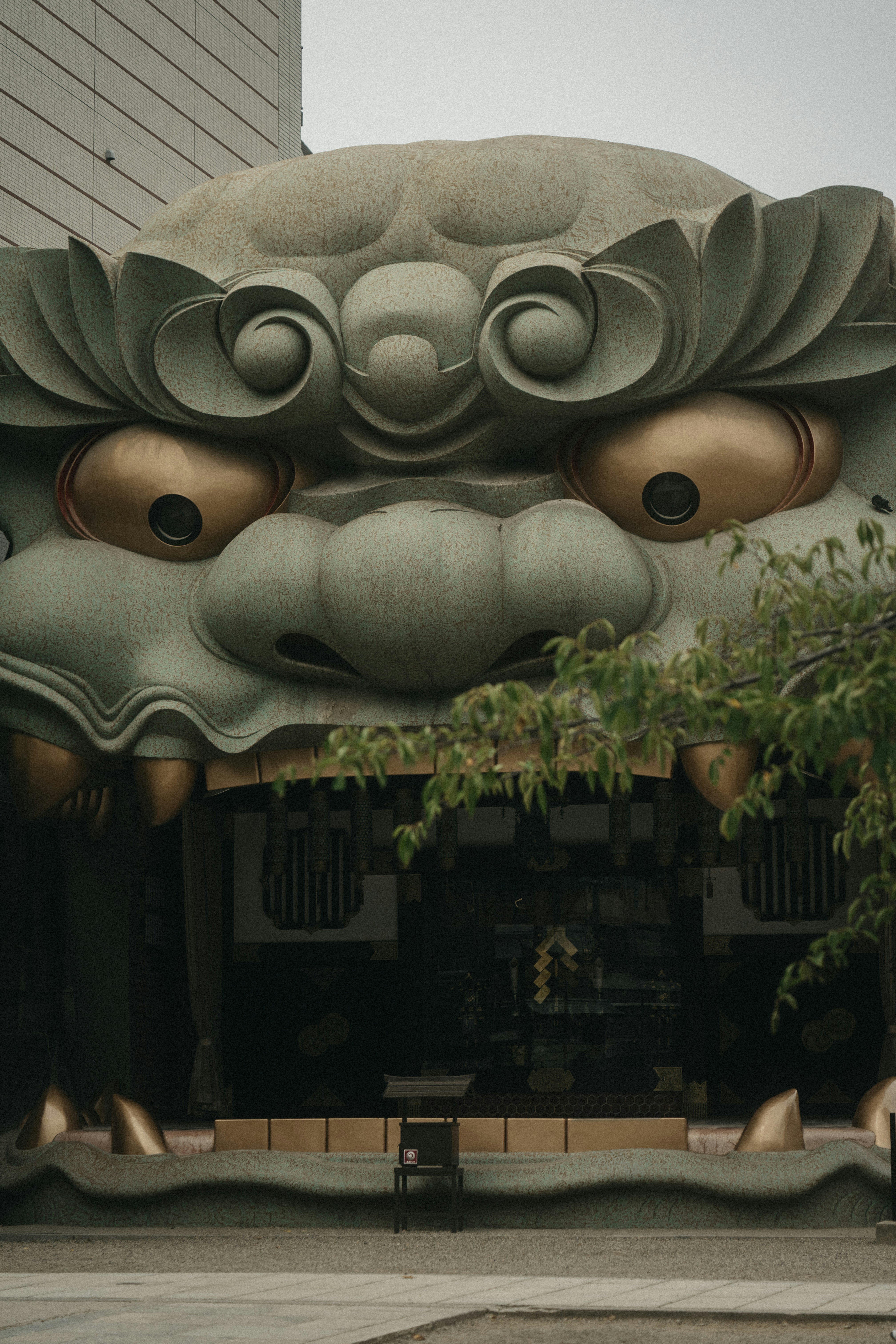 Giant Grinning Guardian: A Sculpted Face Reaching from the Entrance