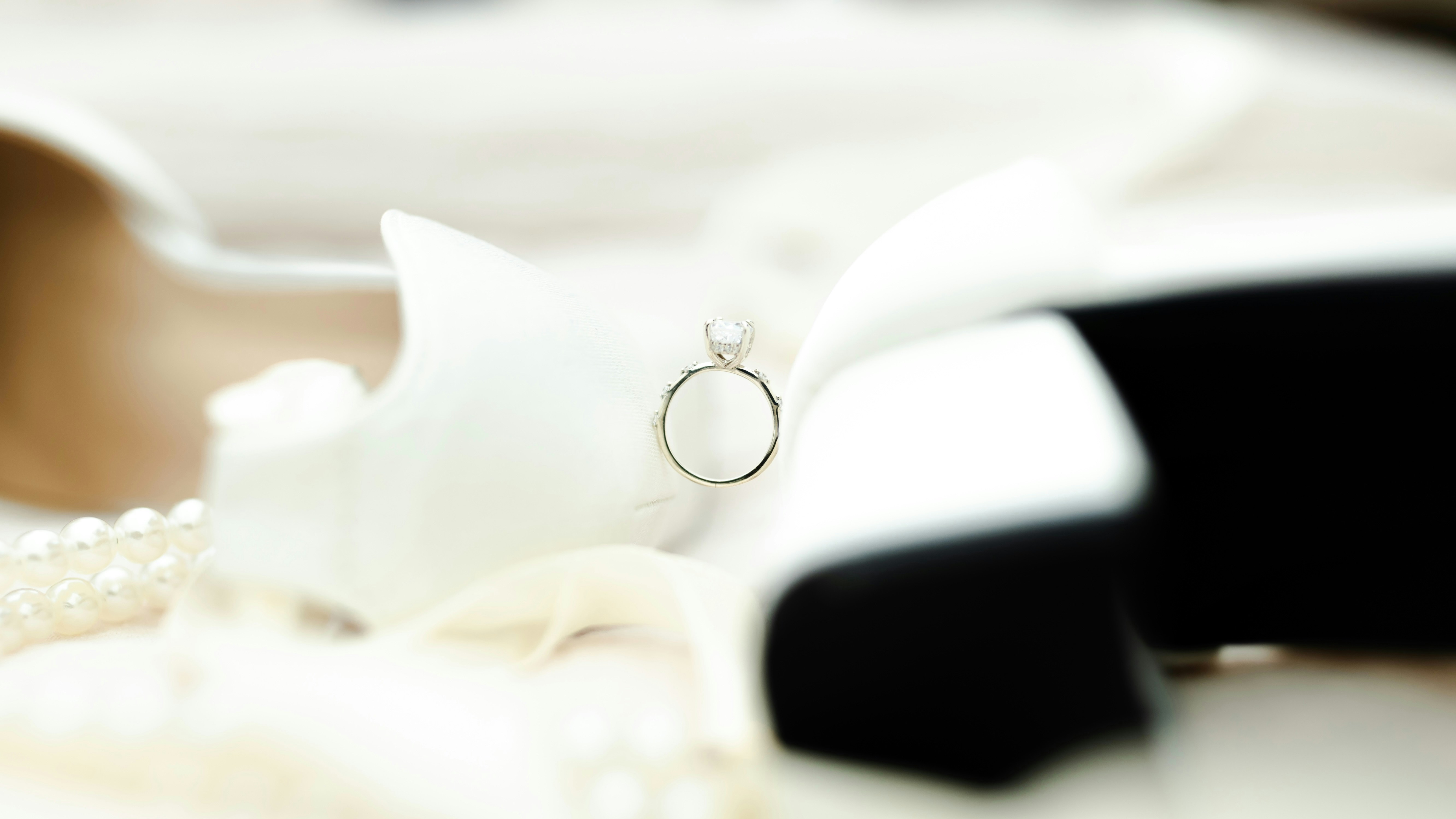Floating Promise: a Diamond Ring Hovering Over Bridal Fabric