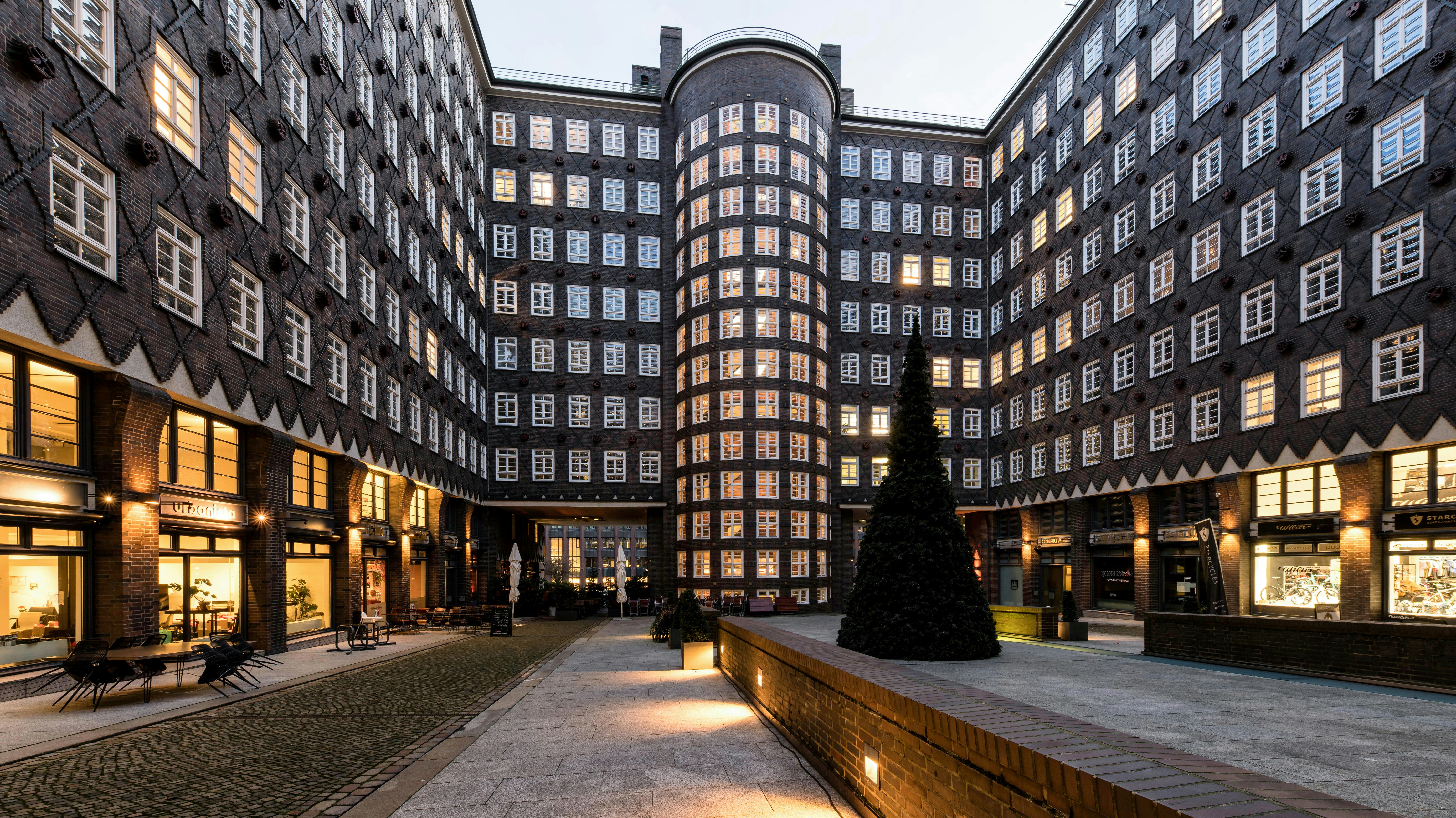 Symmetrical Courtyard Inferno: Glass Atrium Wrapped in Dark Facades