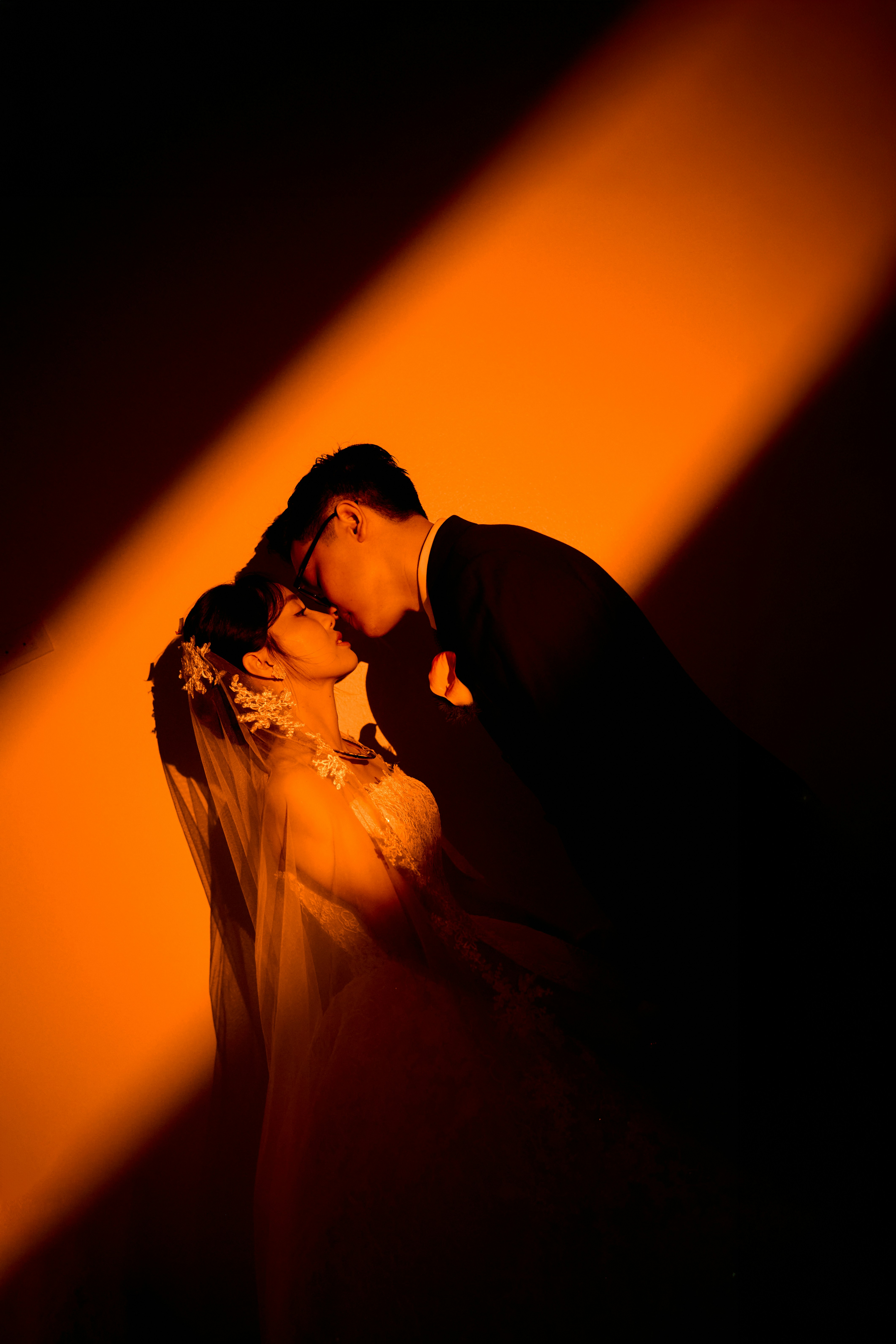 Kiss in the Spotlight: A Veiled Promise Under an Ember Arc