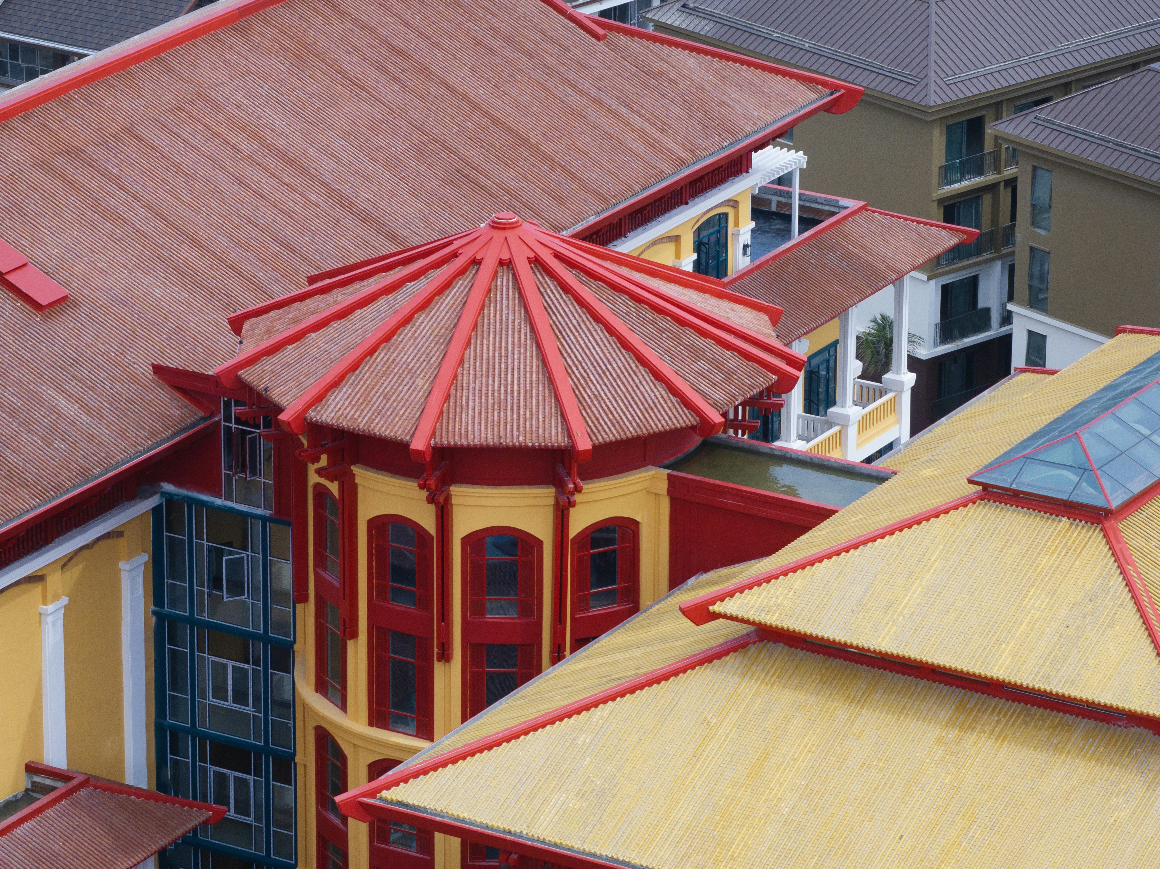 Red-roofed pagoda-like tower among colorful modern roofs