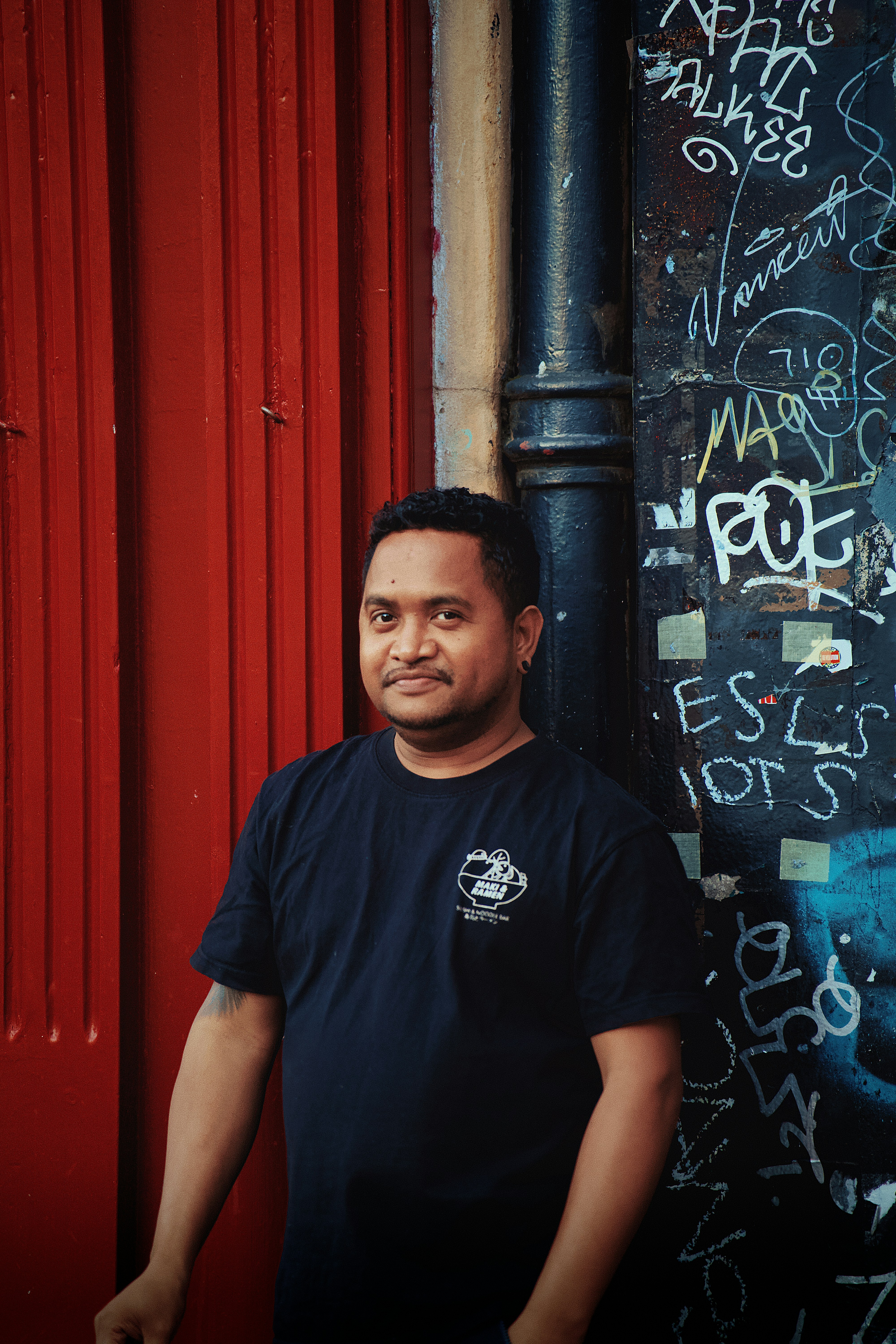 Portrait by the Graffiti Wall: A Calm Presence in Urban Color