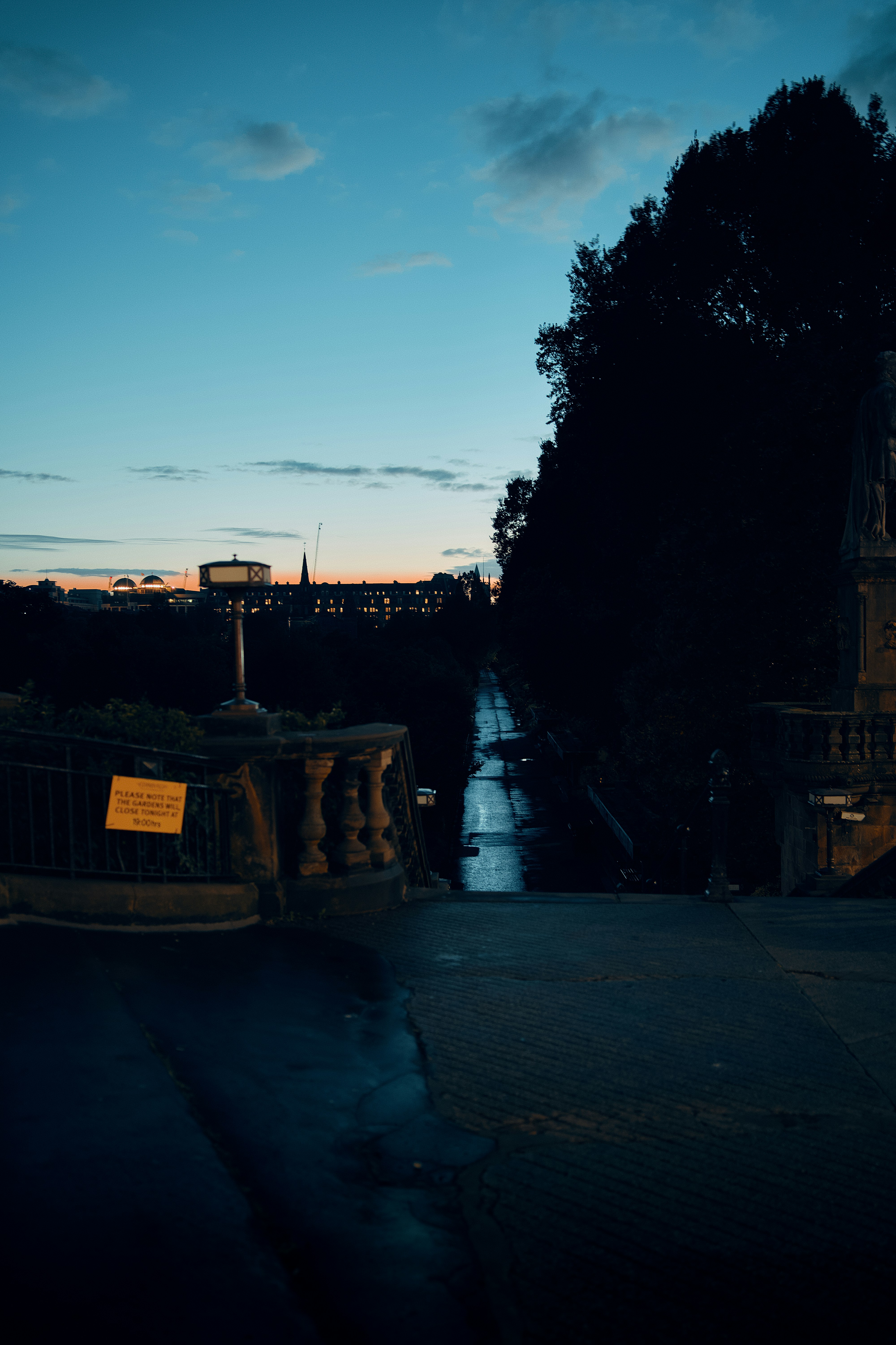 Dusk Over the Riverwalk: Lanterns, Steps, and Shadowed Archways