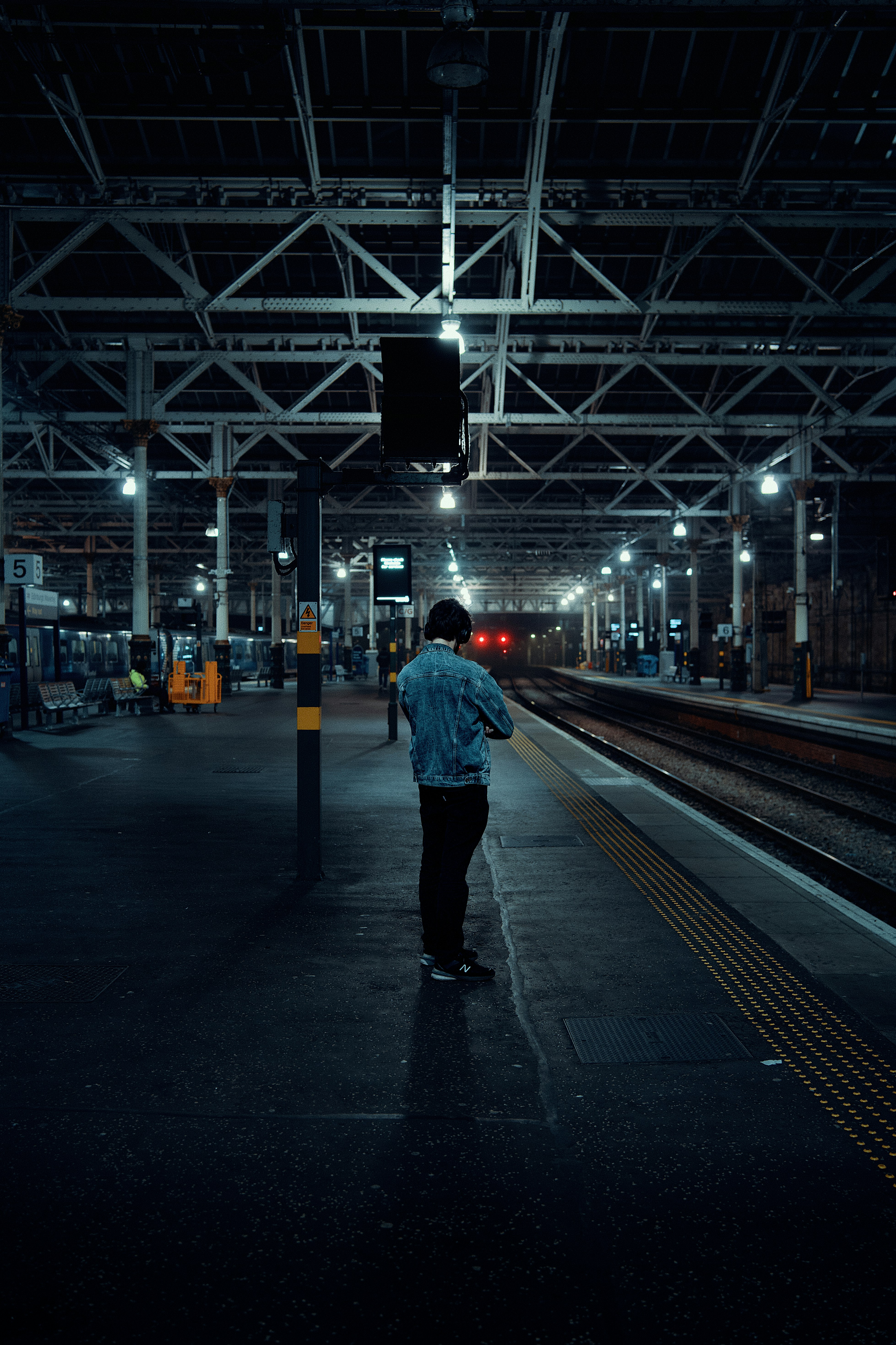 Midnight Solo: A Figure Stands Vigil at the Timeless Train Platform