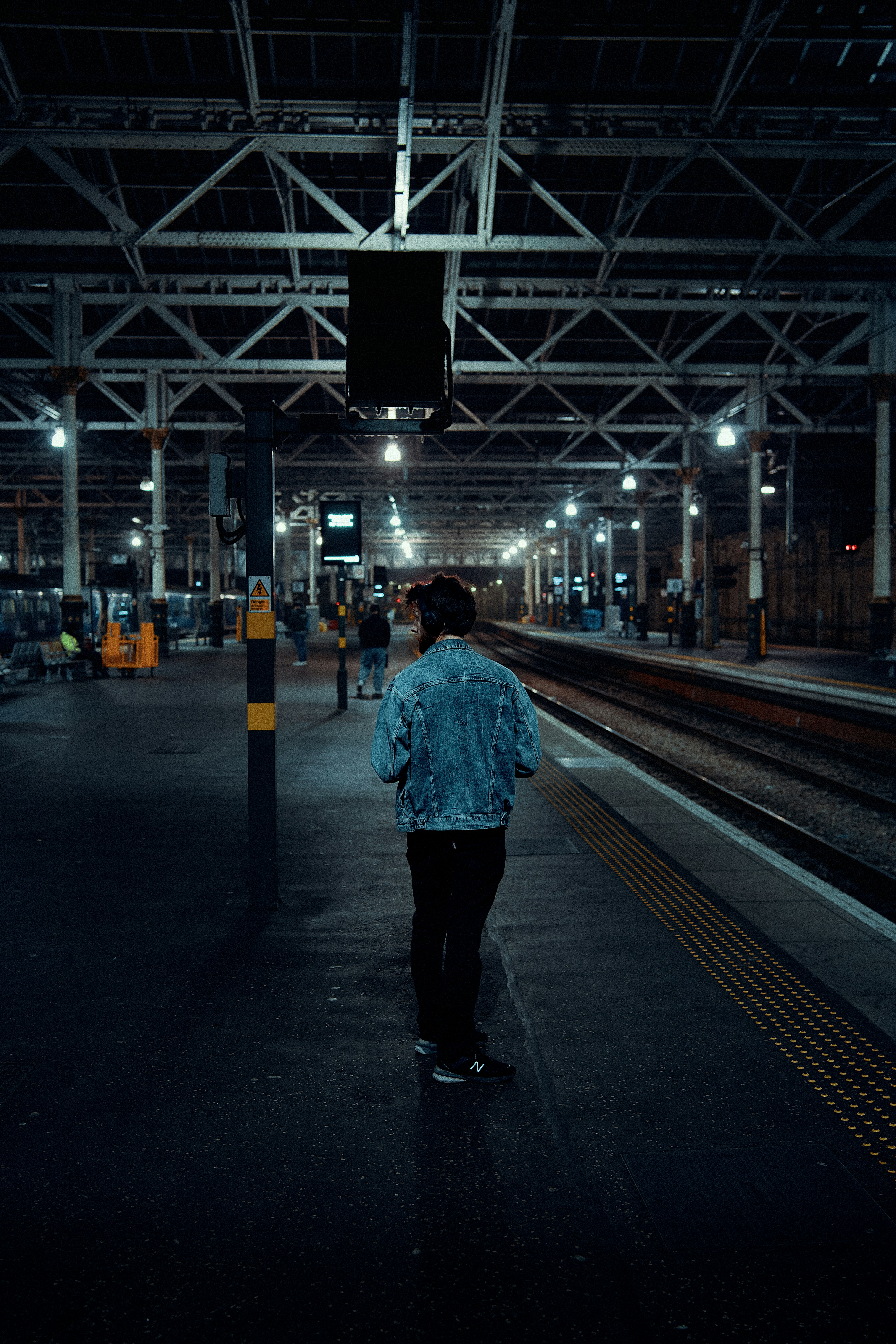 Midnight Platform: A Denim-Clad Stranger under Industrial Glow