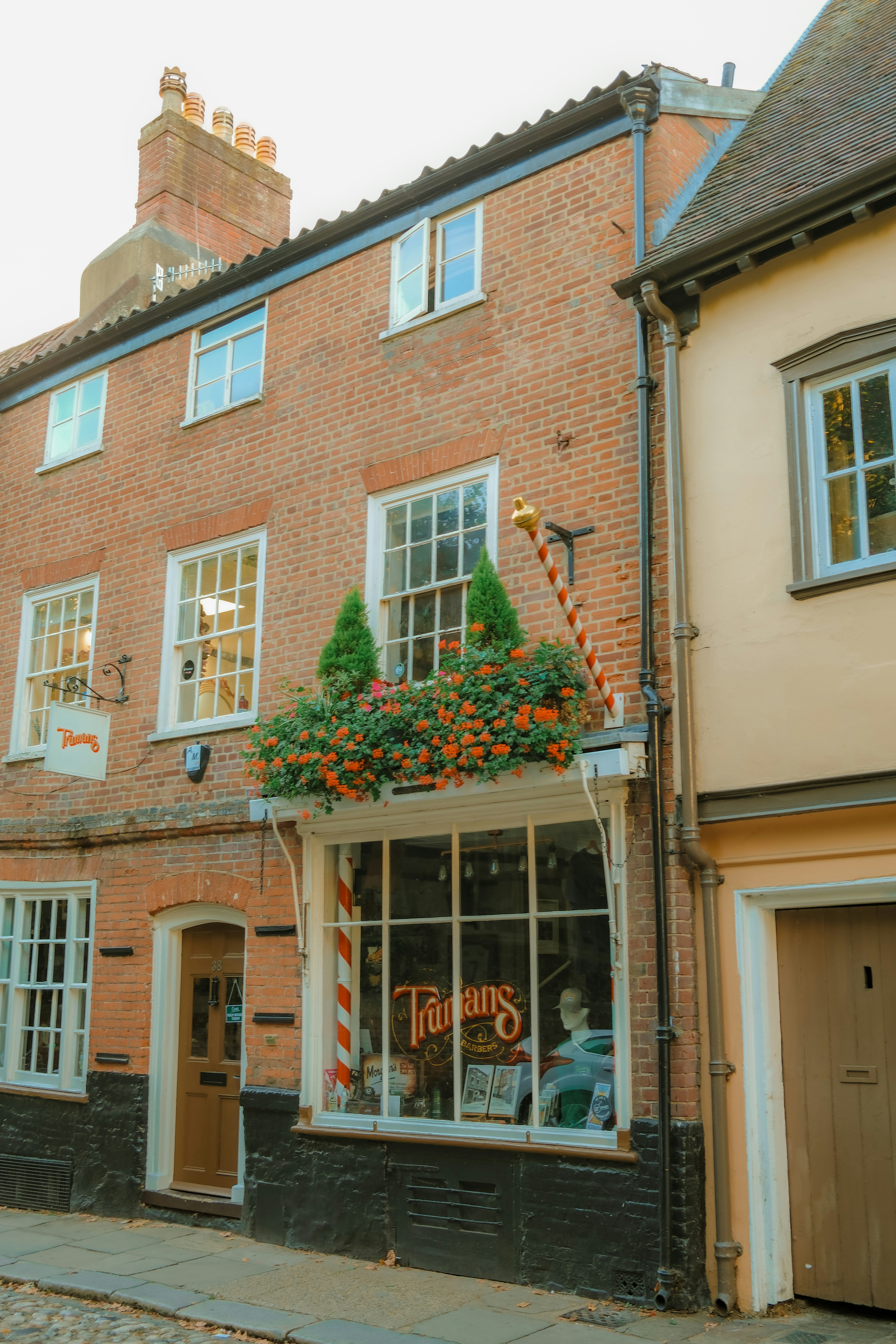 Floral Window Canopy Over a Brick Townshop