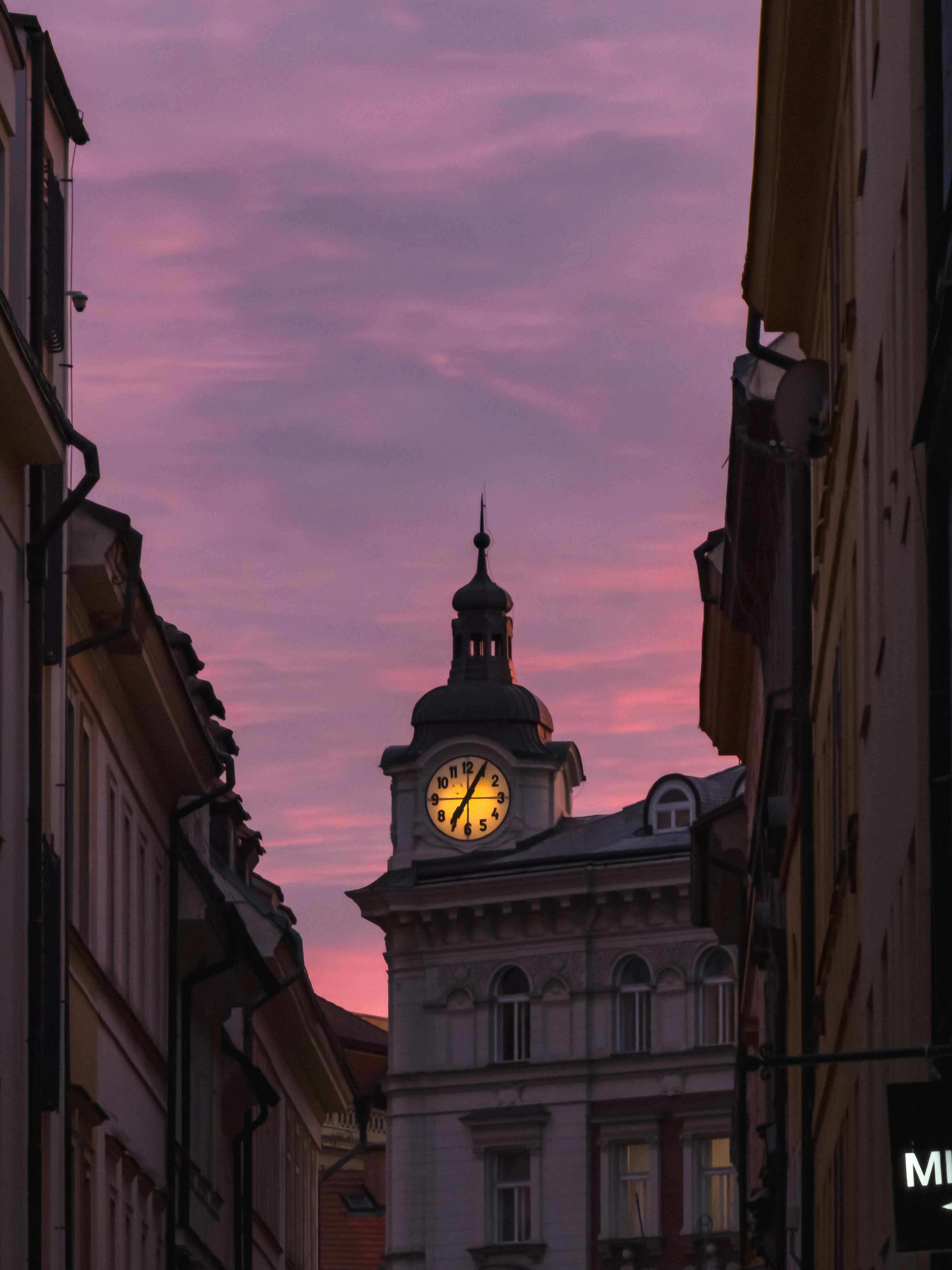 Twilight Clock Tower Silhouette in a Narrow European Street