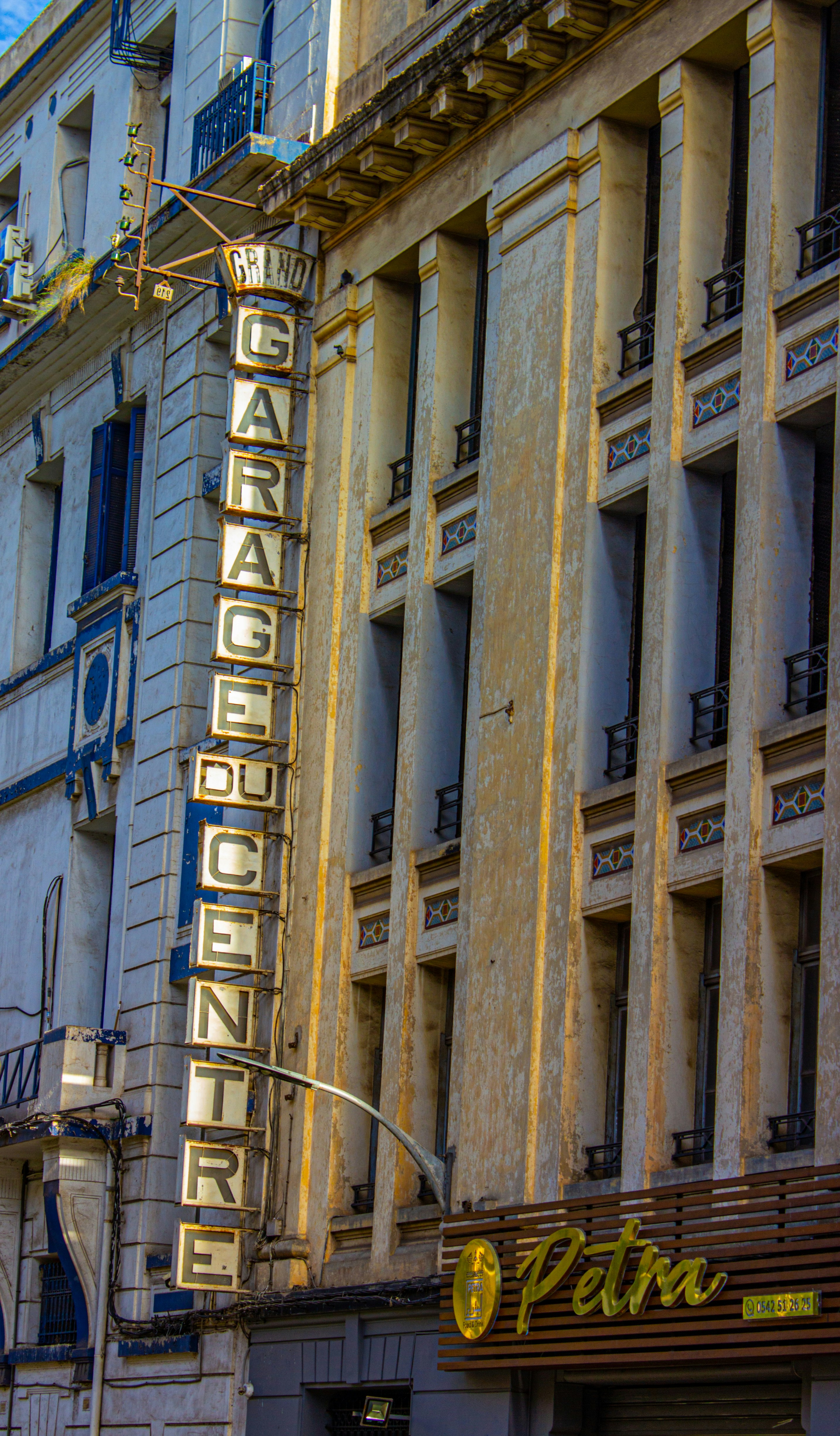 Neon Signage and Art-Deco Facade on a Weathered Calle