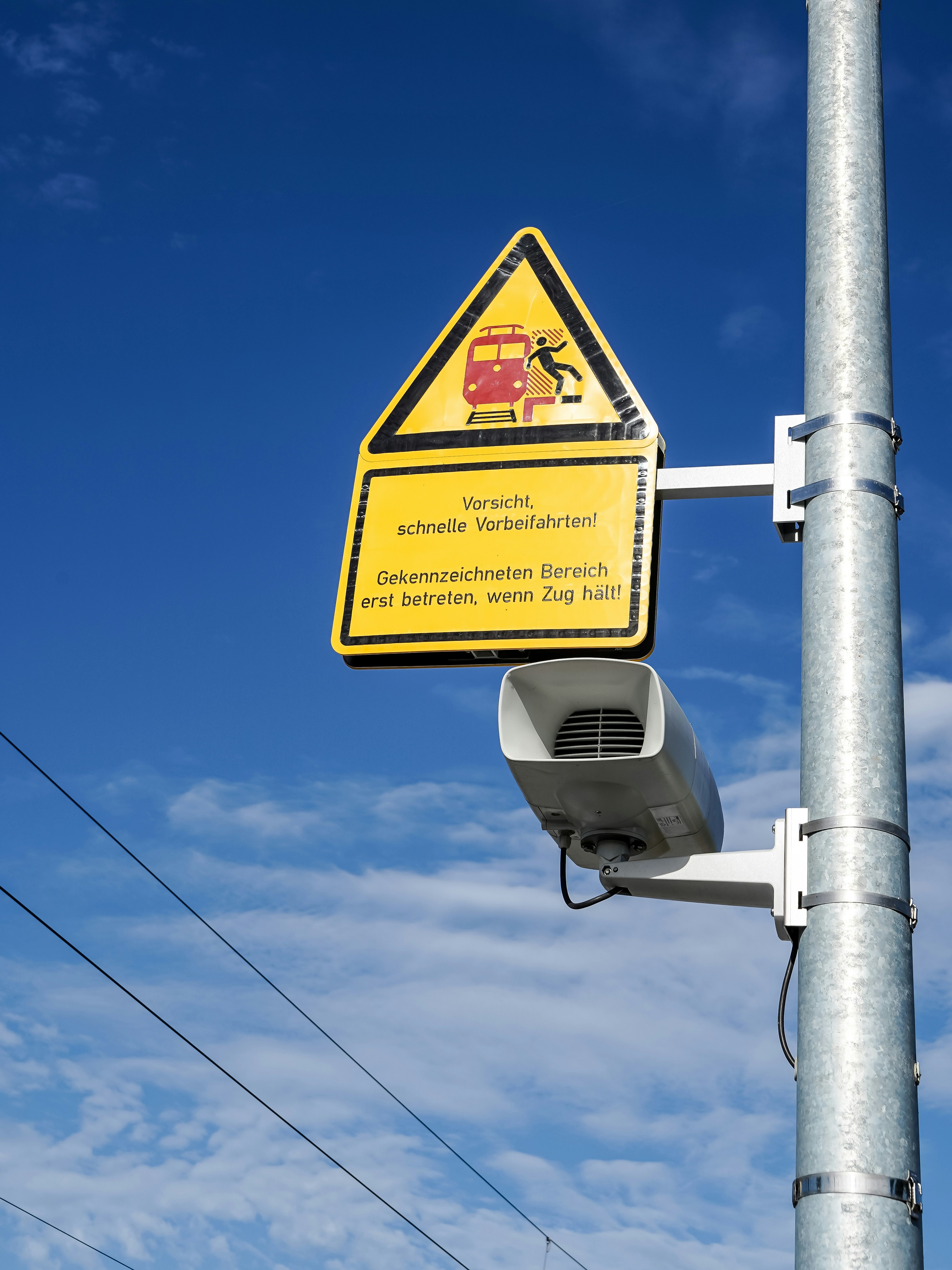 Warning Sign Over a Street: Caution for Quick Trains