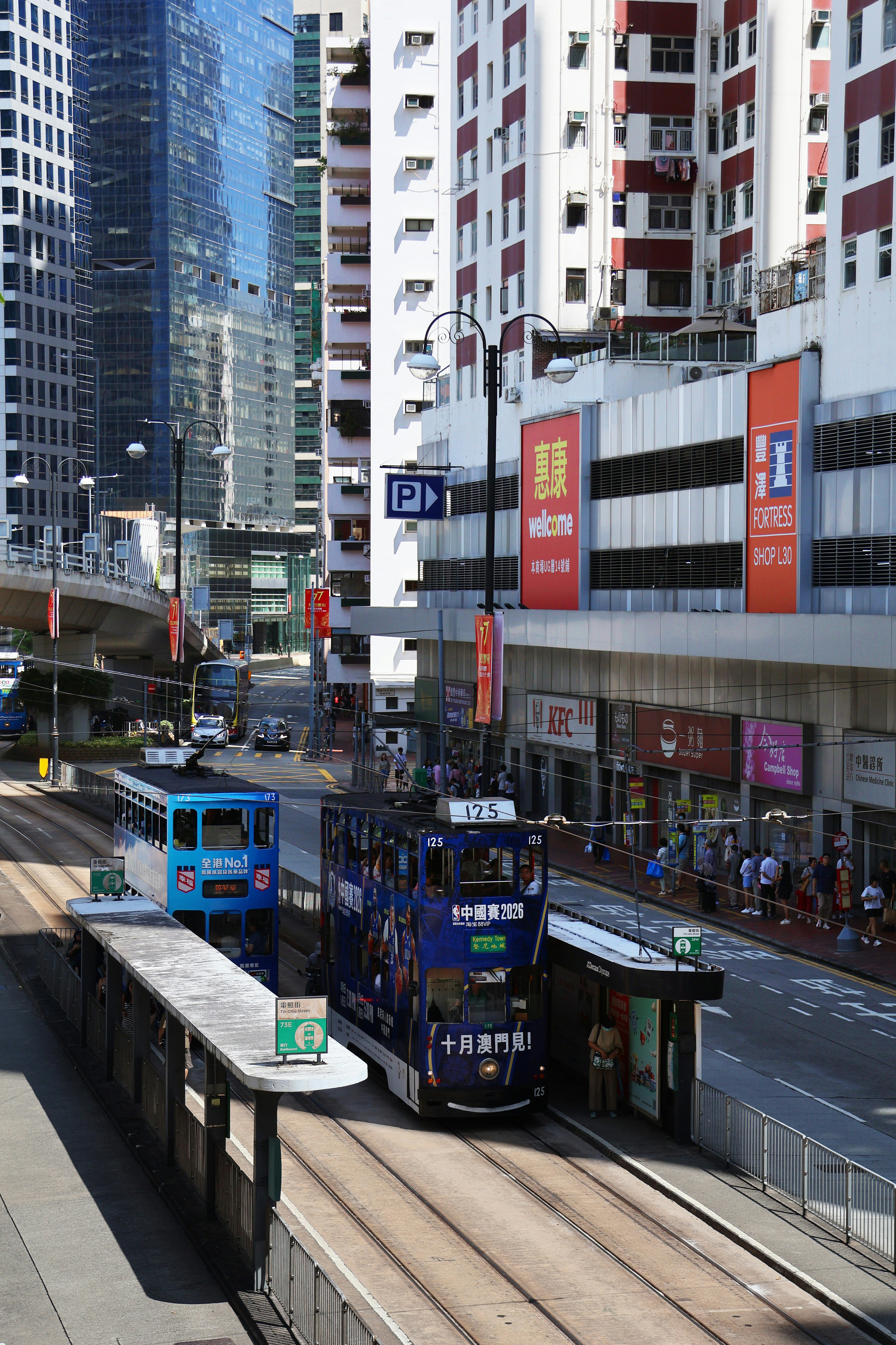 Blue Tram in a Busy Urban Corridor