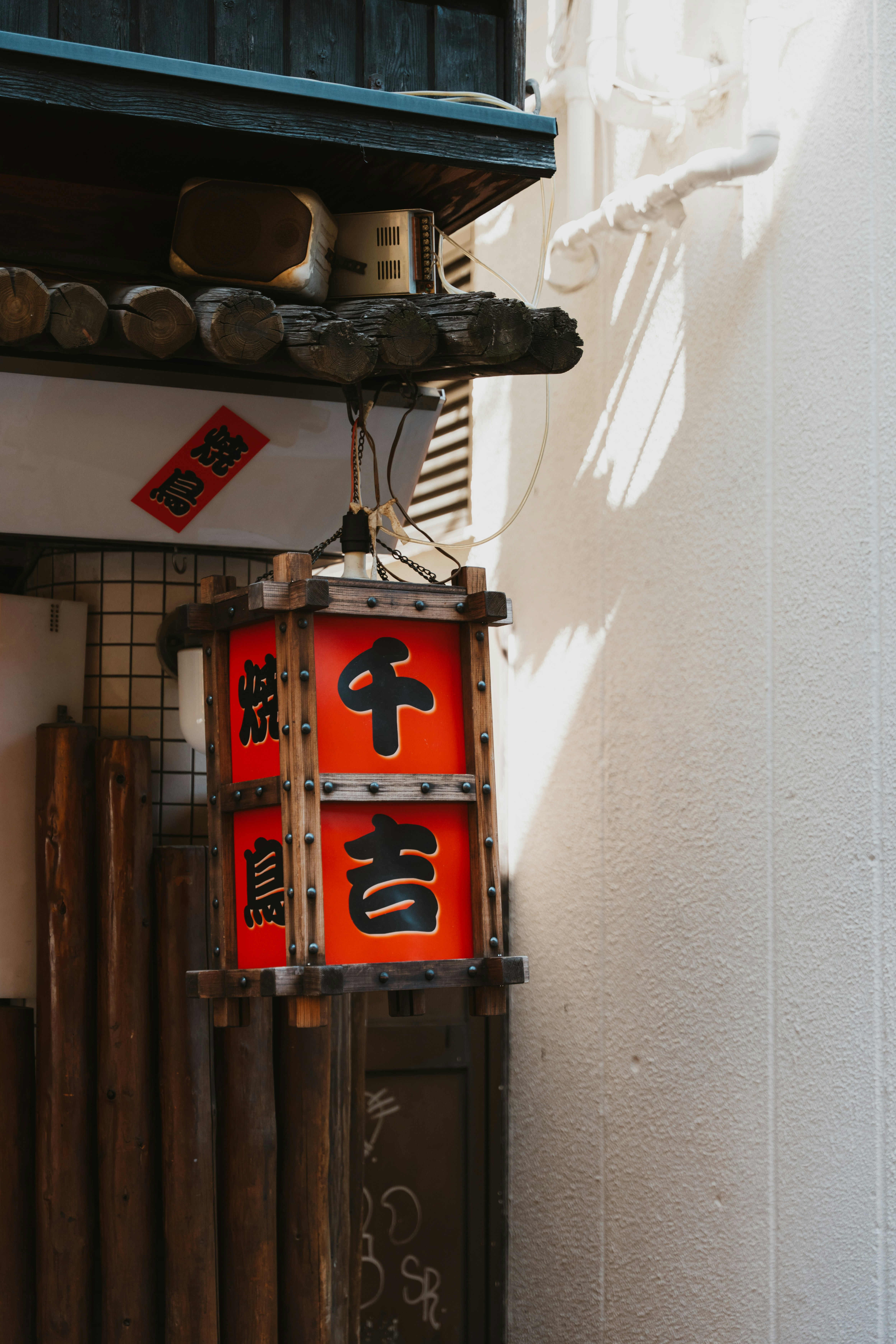 Red Lanterns and Wooden Signage in a Quiet Alley