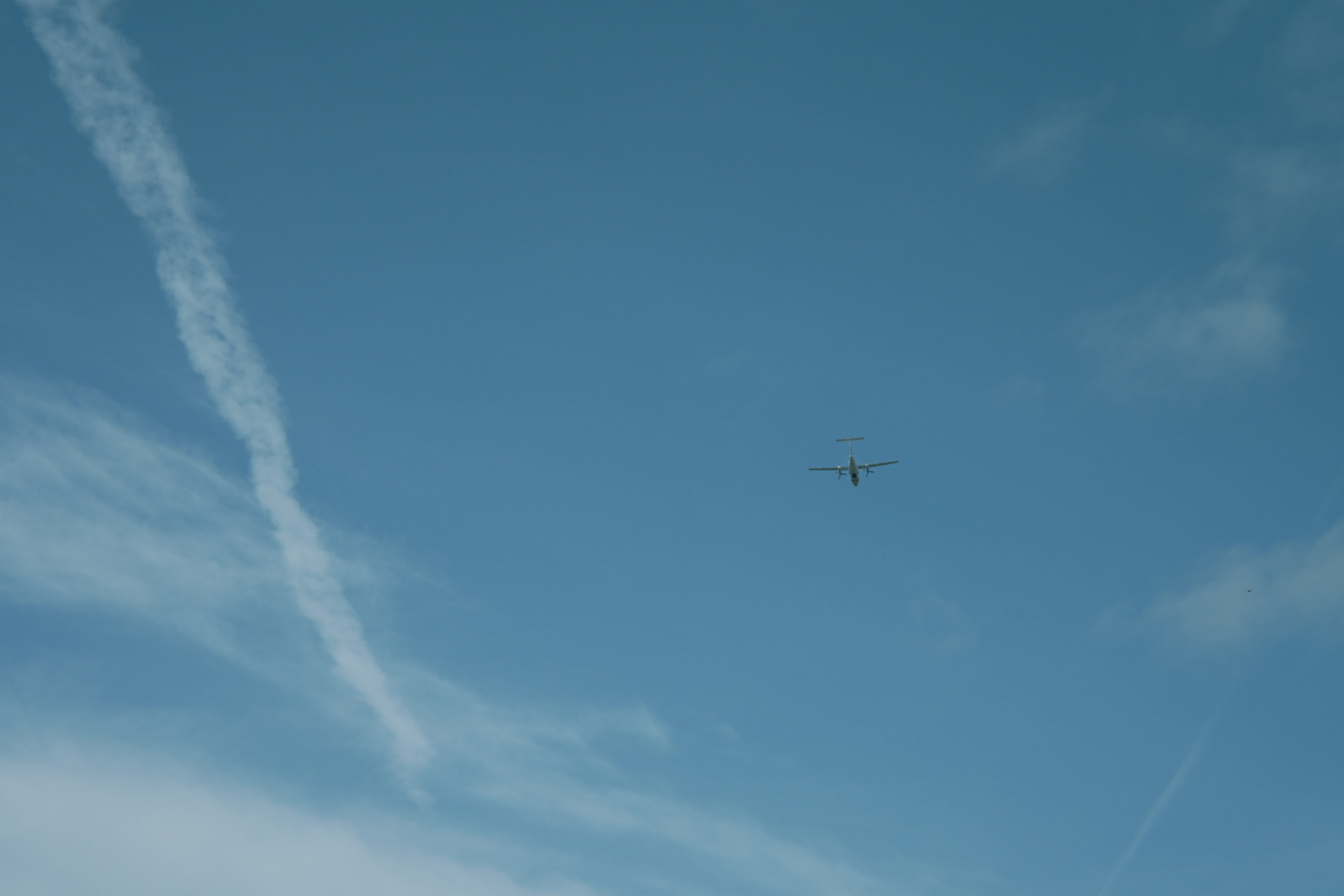 Skybound Speck: A lone jet traced against a crisp blue expanse