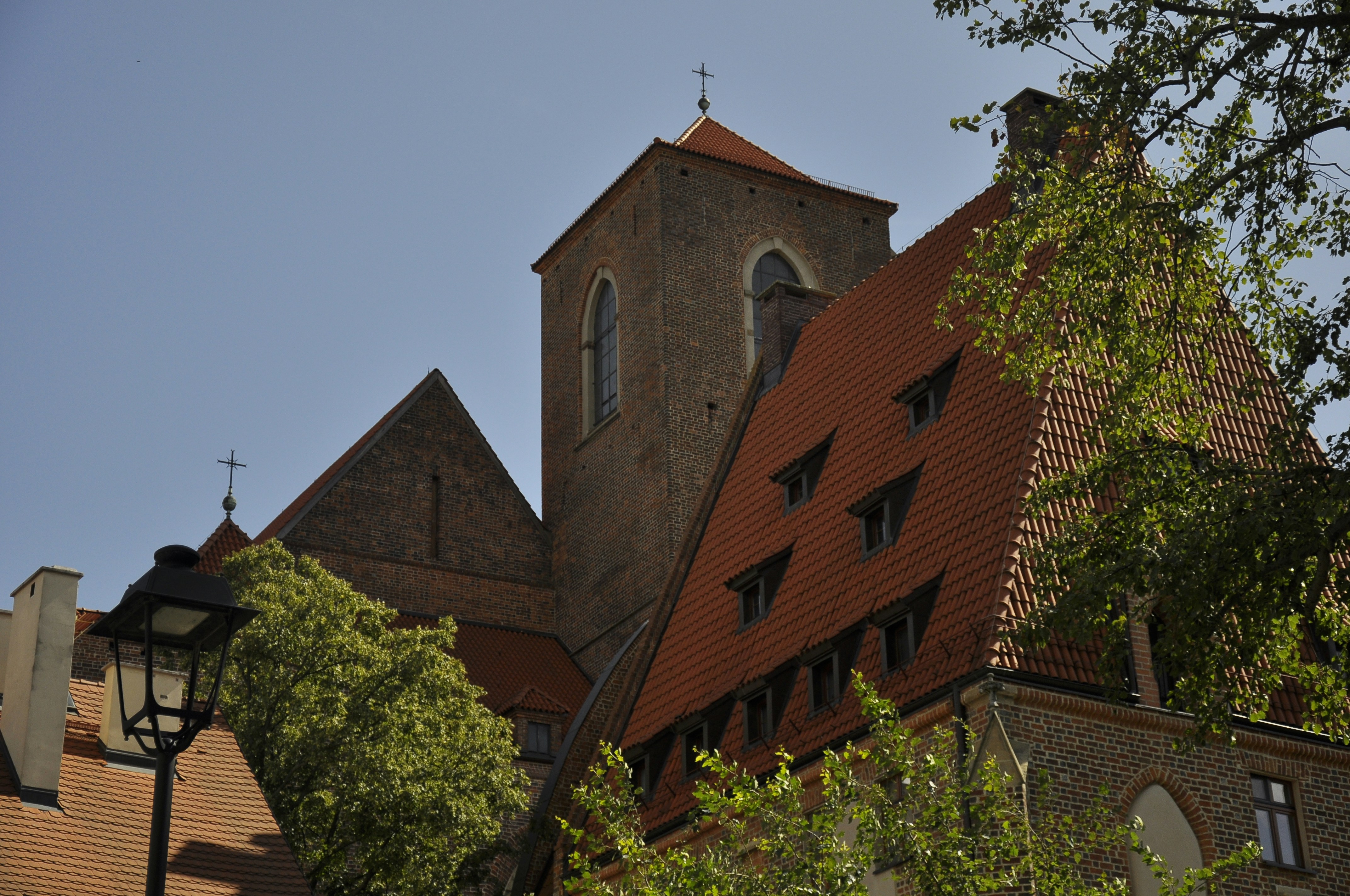Sunlit Abbey Facade Under Red-Tiled Staircase Roof