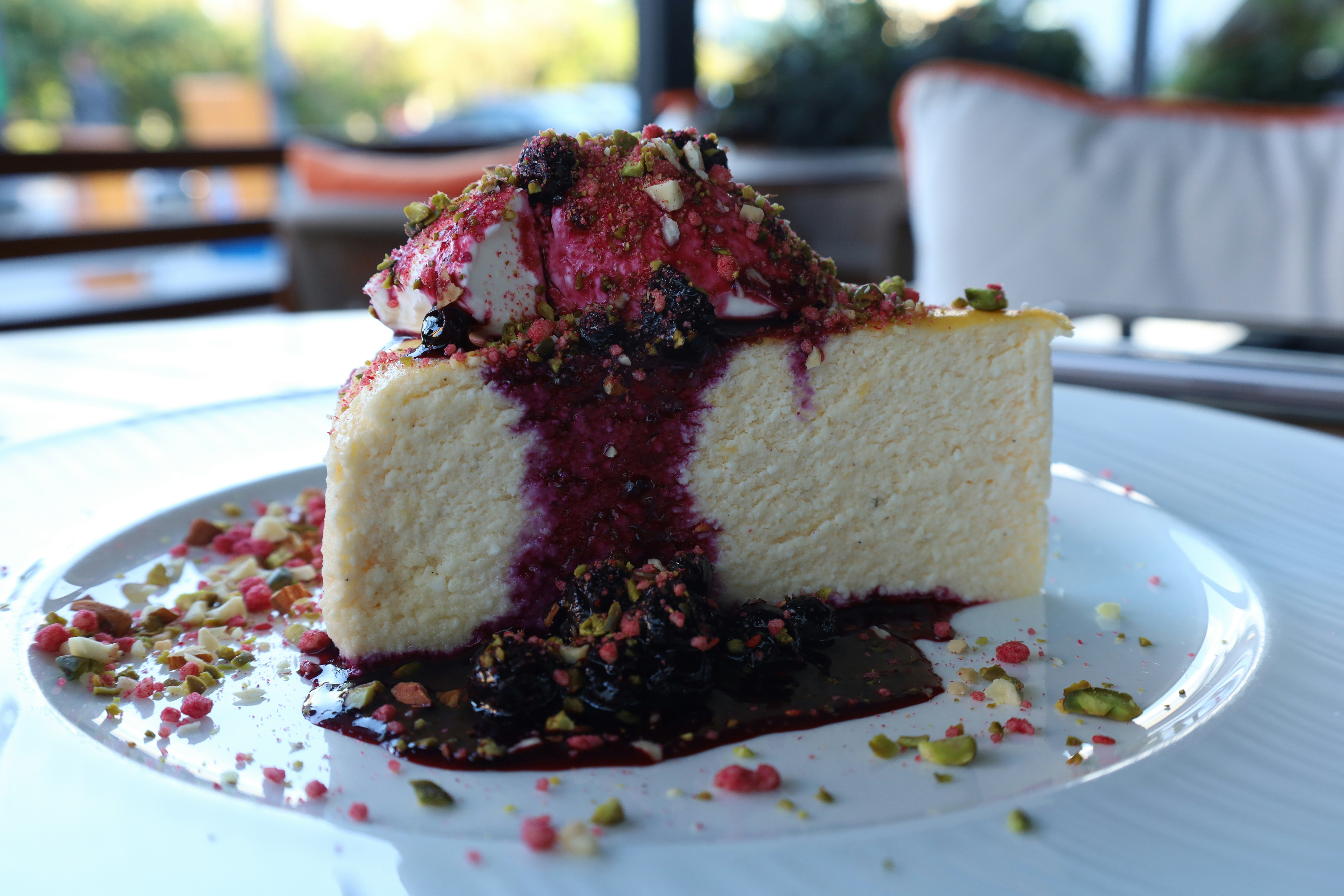 Berry-drizzled Cheesecake Slice on a Glazed Plate