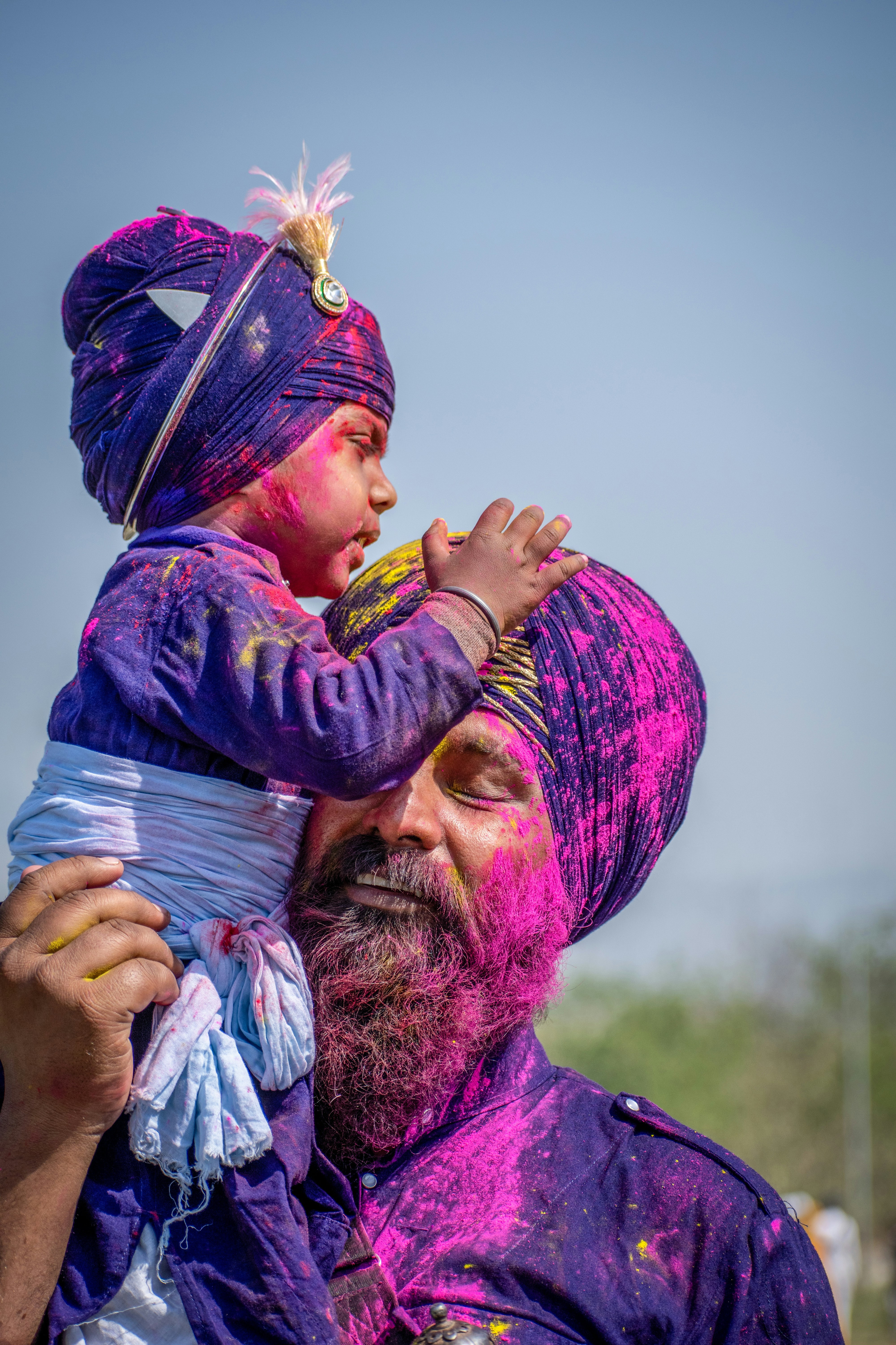 Colorful Holi Embrace: A Grandfather and Grandchild Share a Joyful Moment