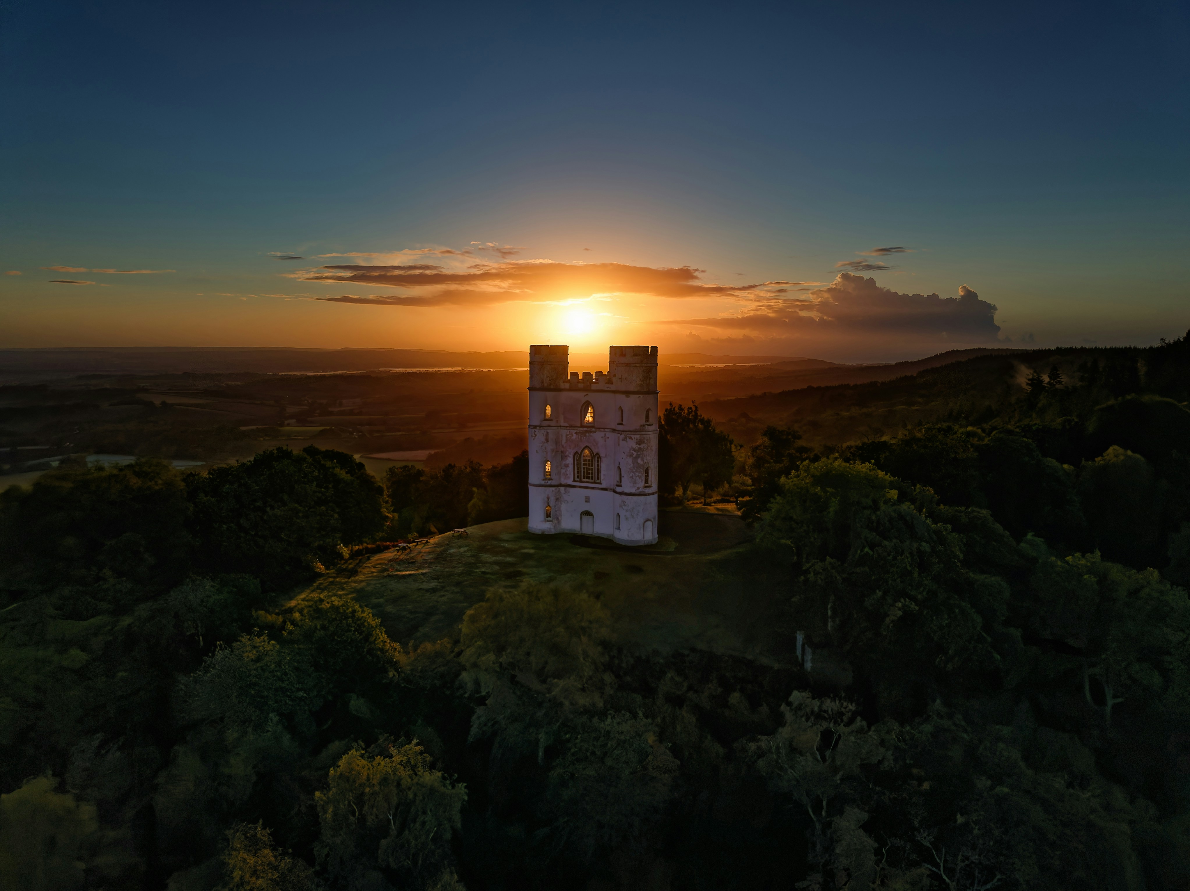 Sunset silhouette: a solitary stone tower crowned by warm skies