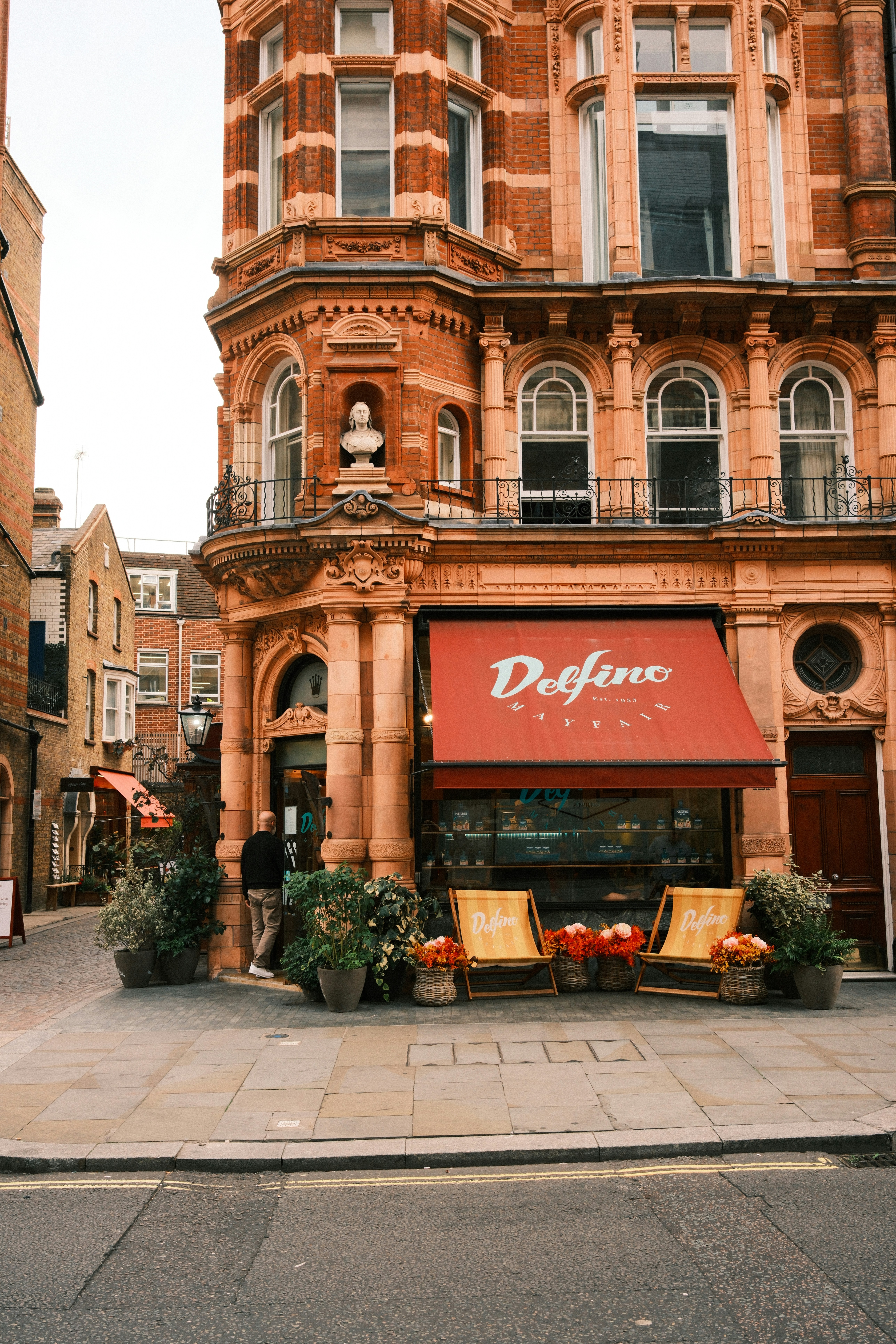 Red Canopy, Brick Facade: A Café on a Historic London-esque Street