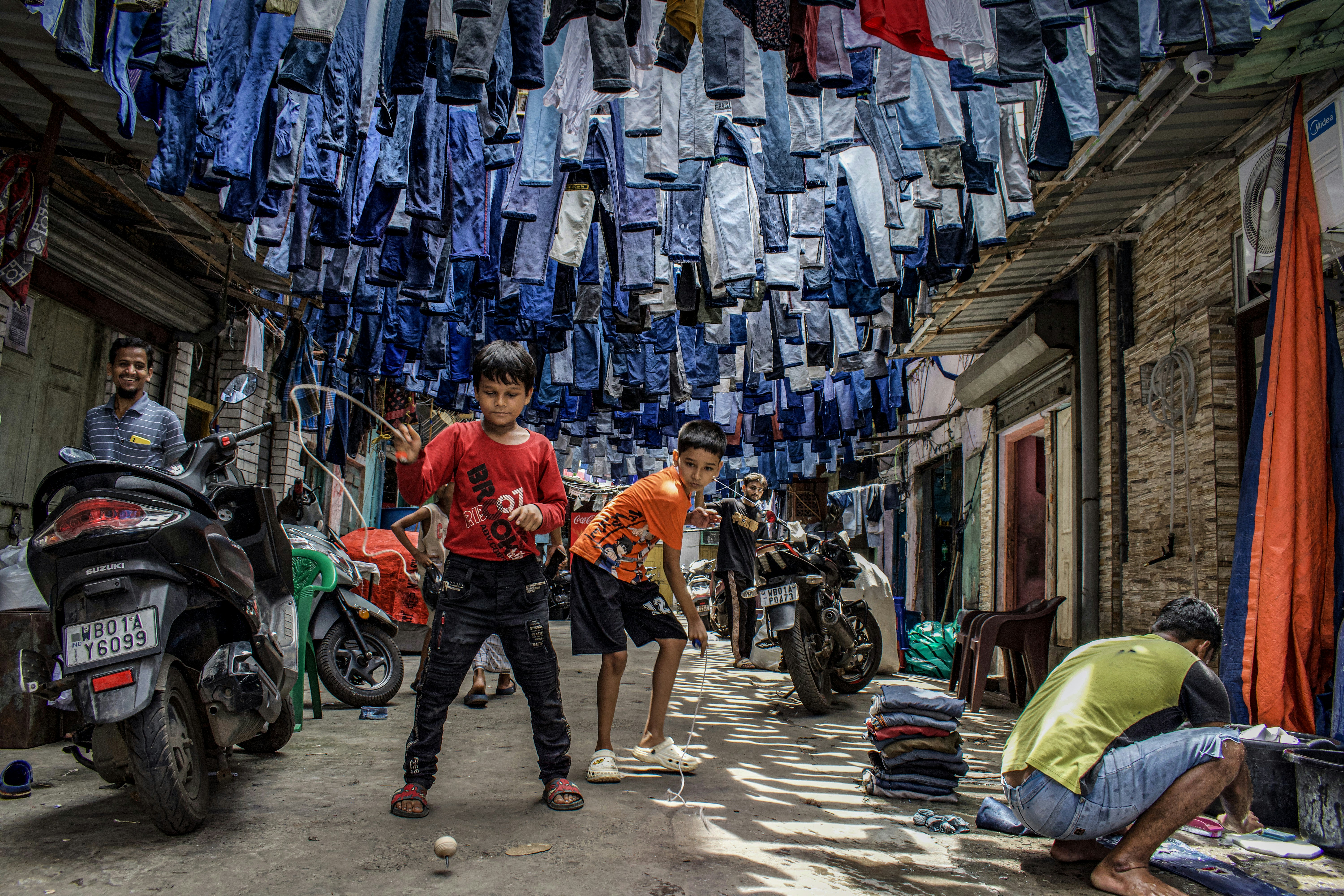Kids in a Laundry-lined Alley: Skating, Shoes, and Colorful Garment Streams