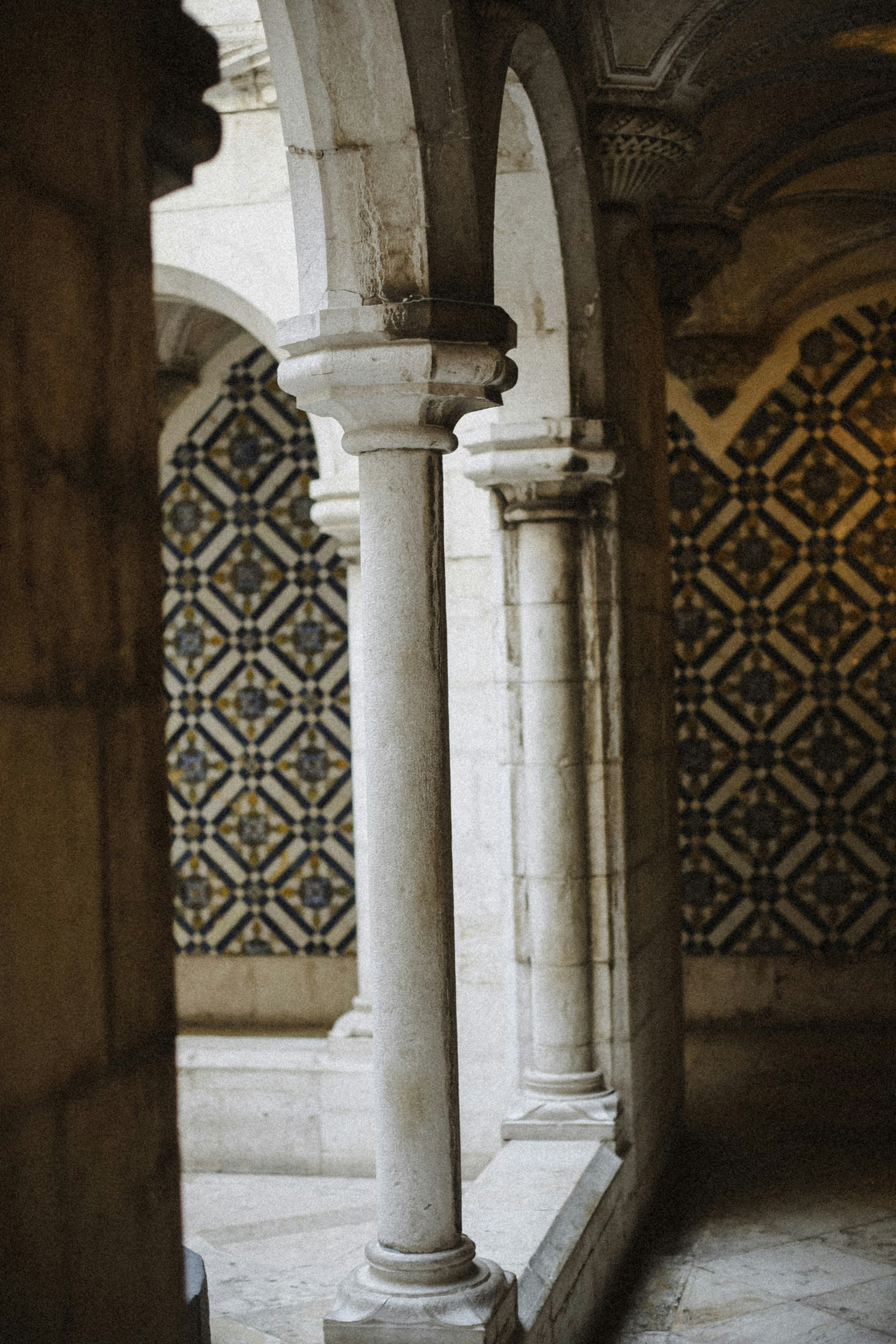 Stone Arches and Tilework: A Quiet Corridor in Repetition