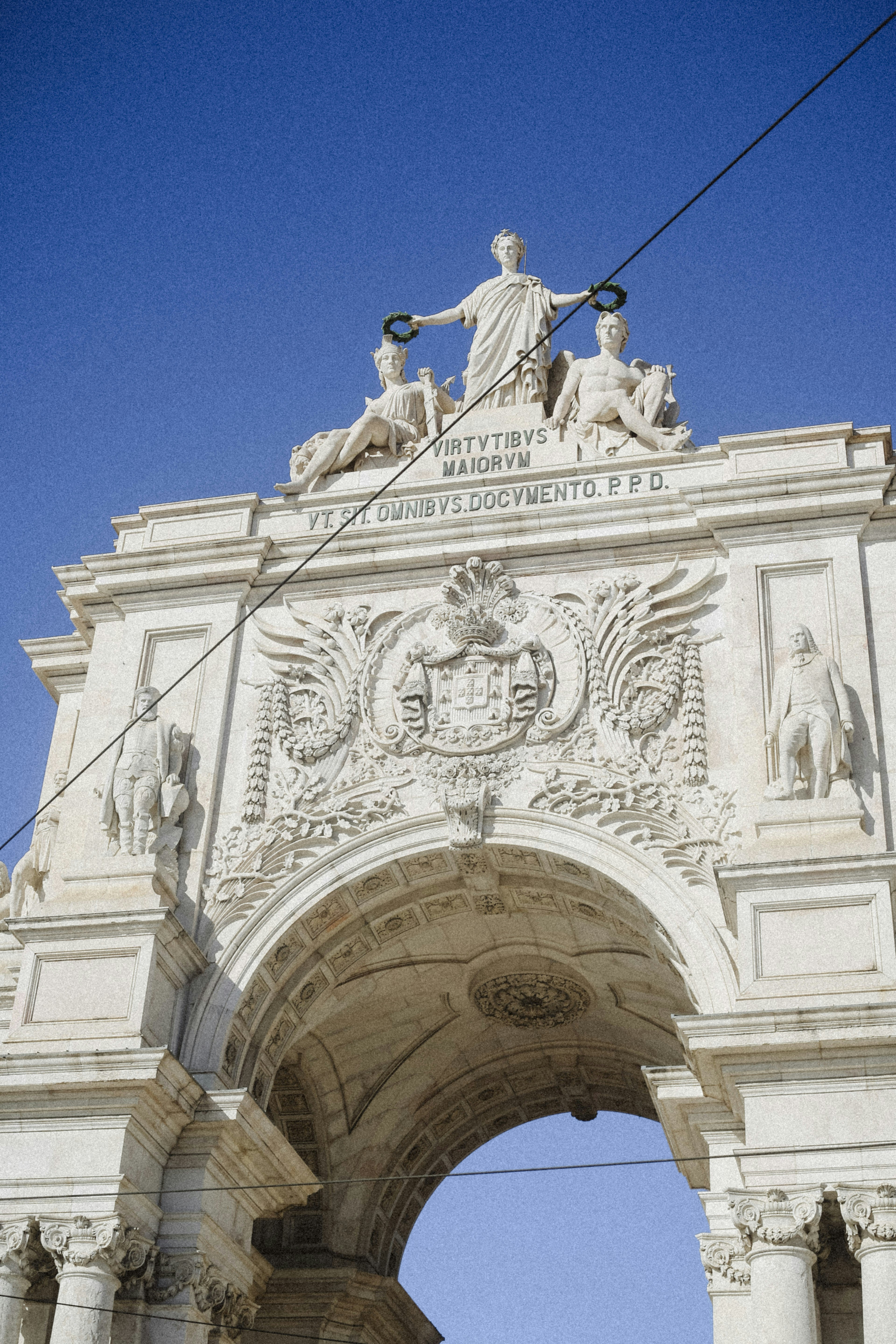 Triumphal Arch Crowned by Allegorical Statues Against a Clear Blue Sky