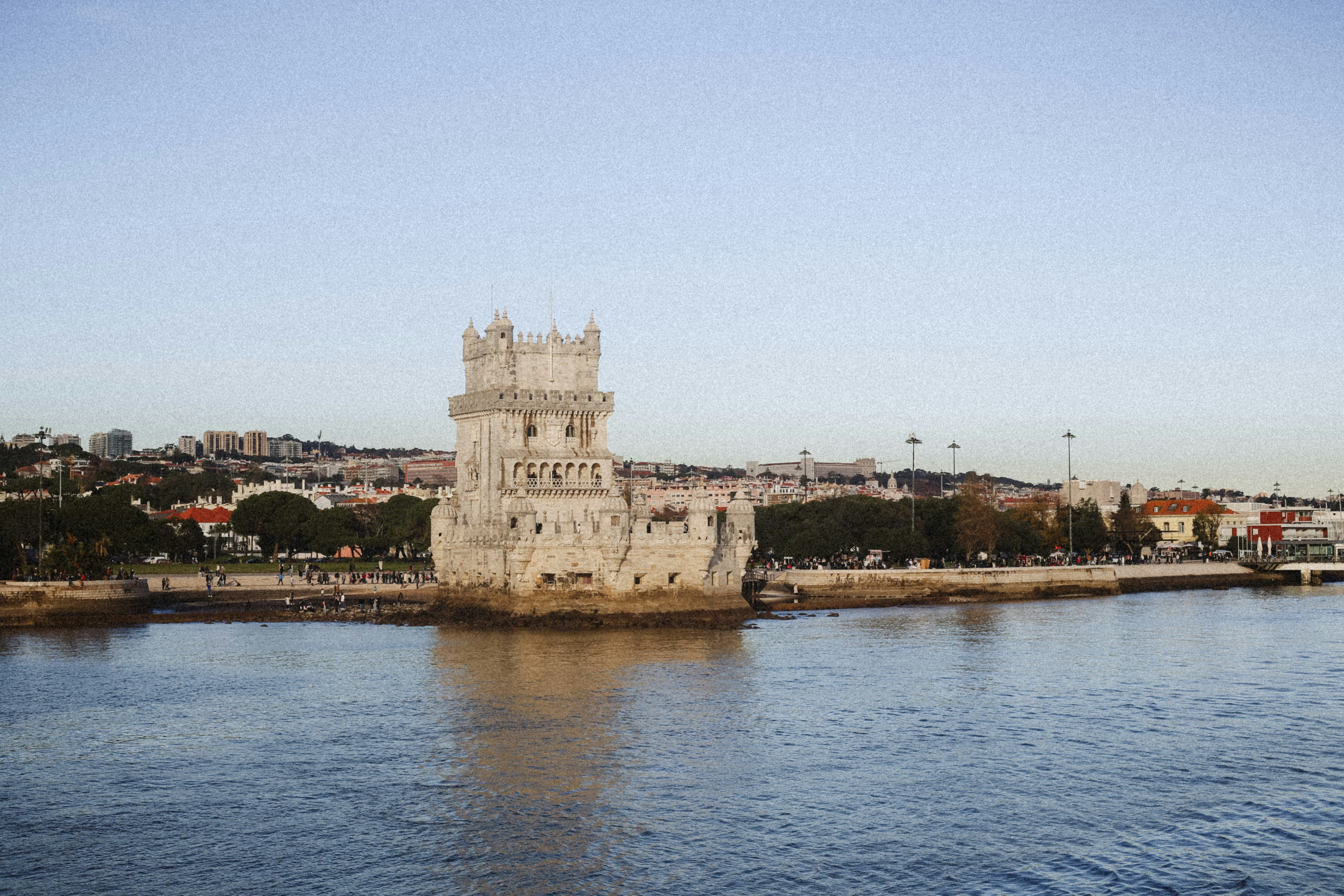 Tower by the Golden Shore: A Coastal Fortress Rising from Calm Waters