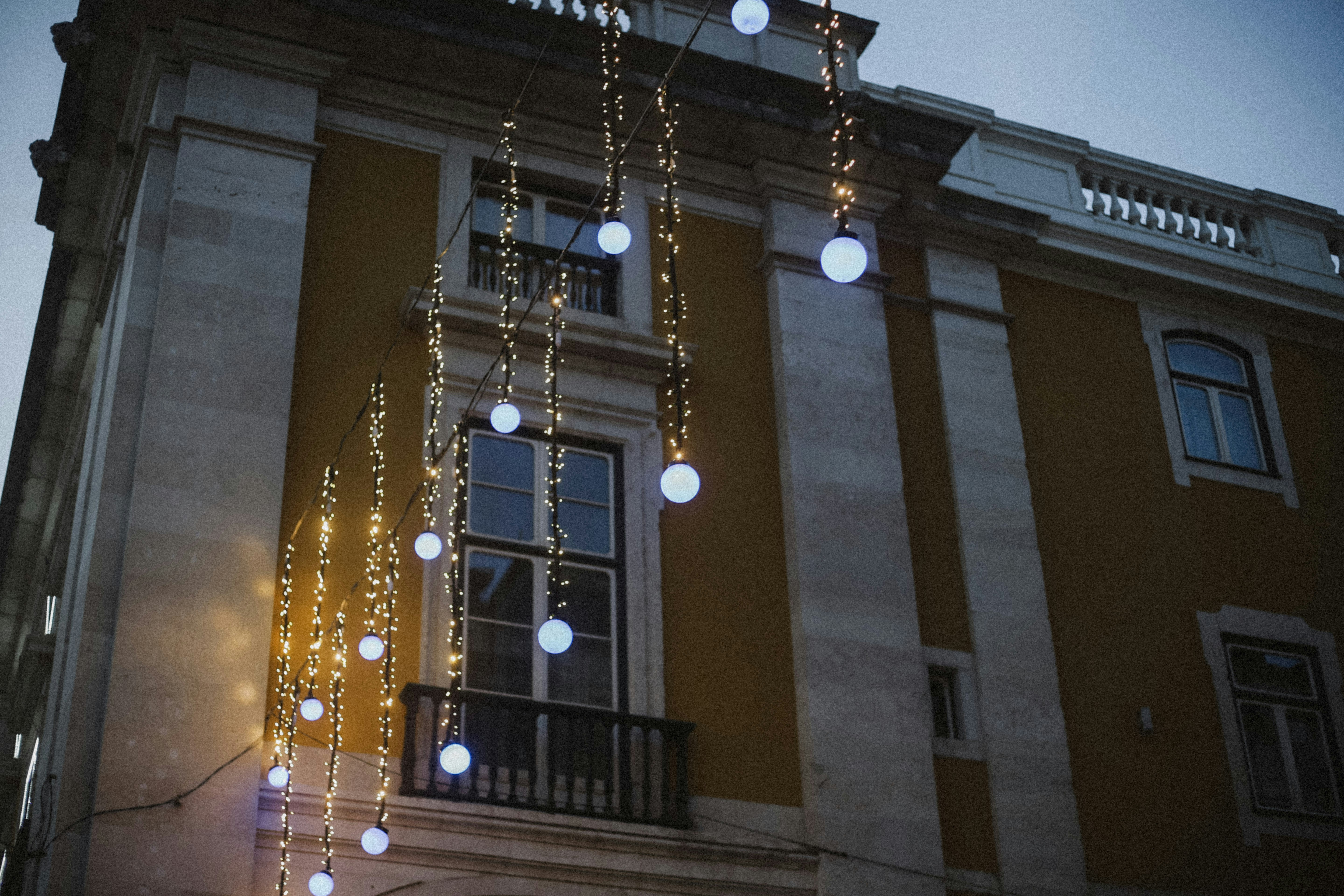 Golden orbs in the evening glow along a historic facade