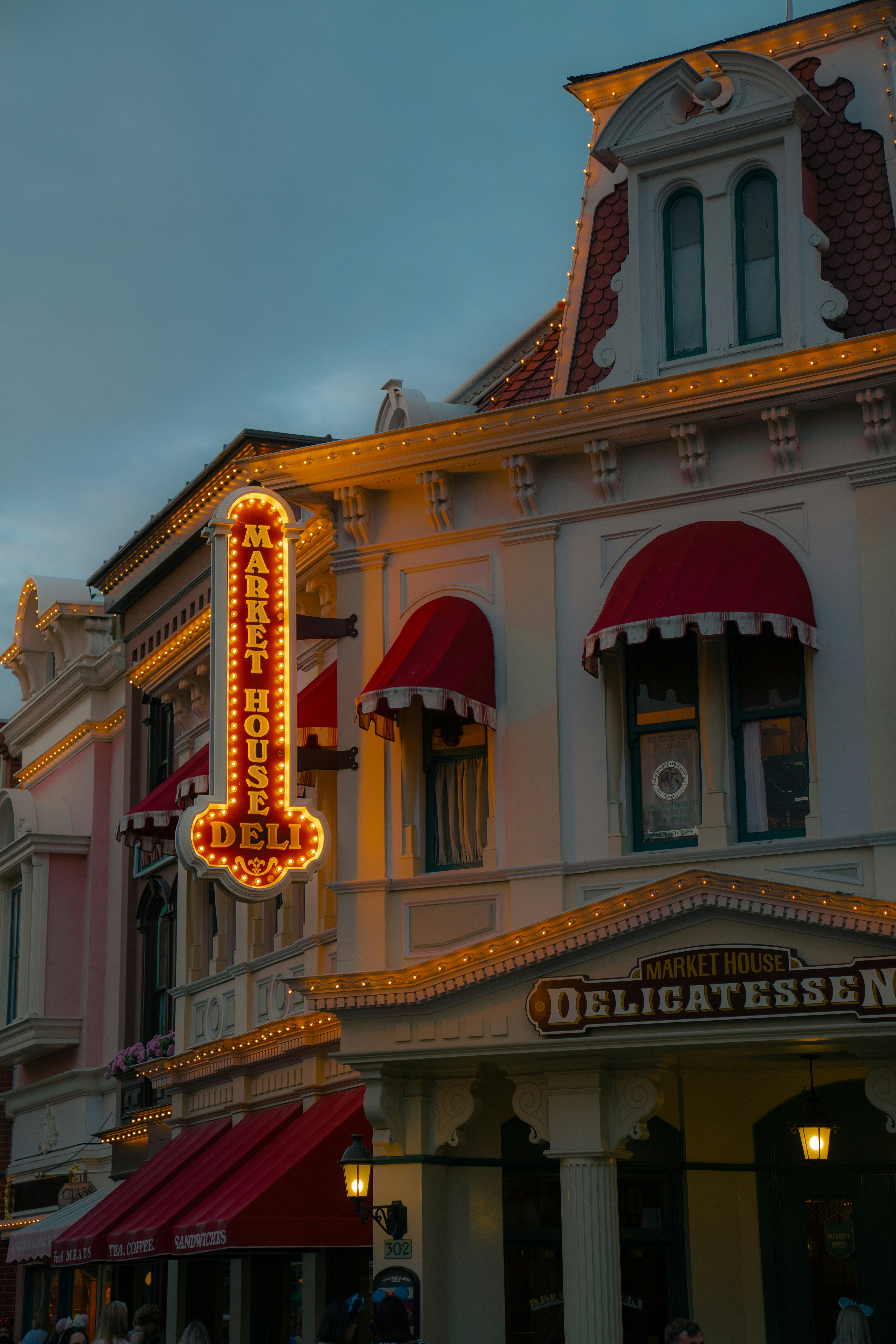 Neon Signage and Delicatessen Façade Under Evening Glow