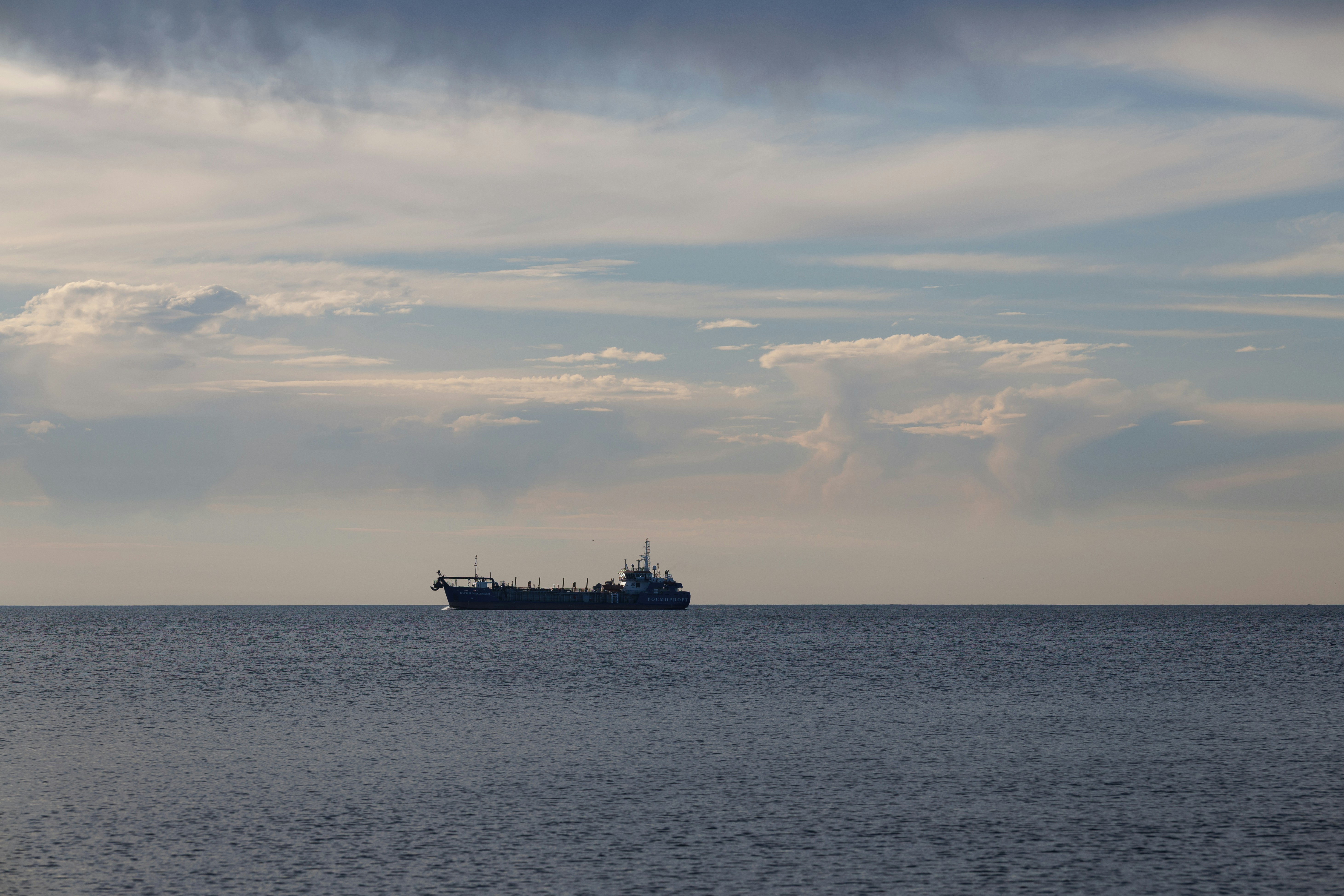  lone cargo vessel on a calm horizon