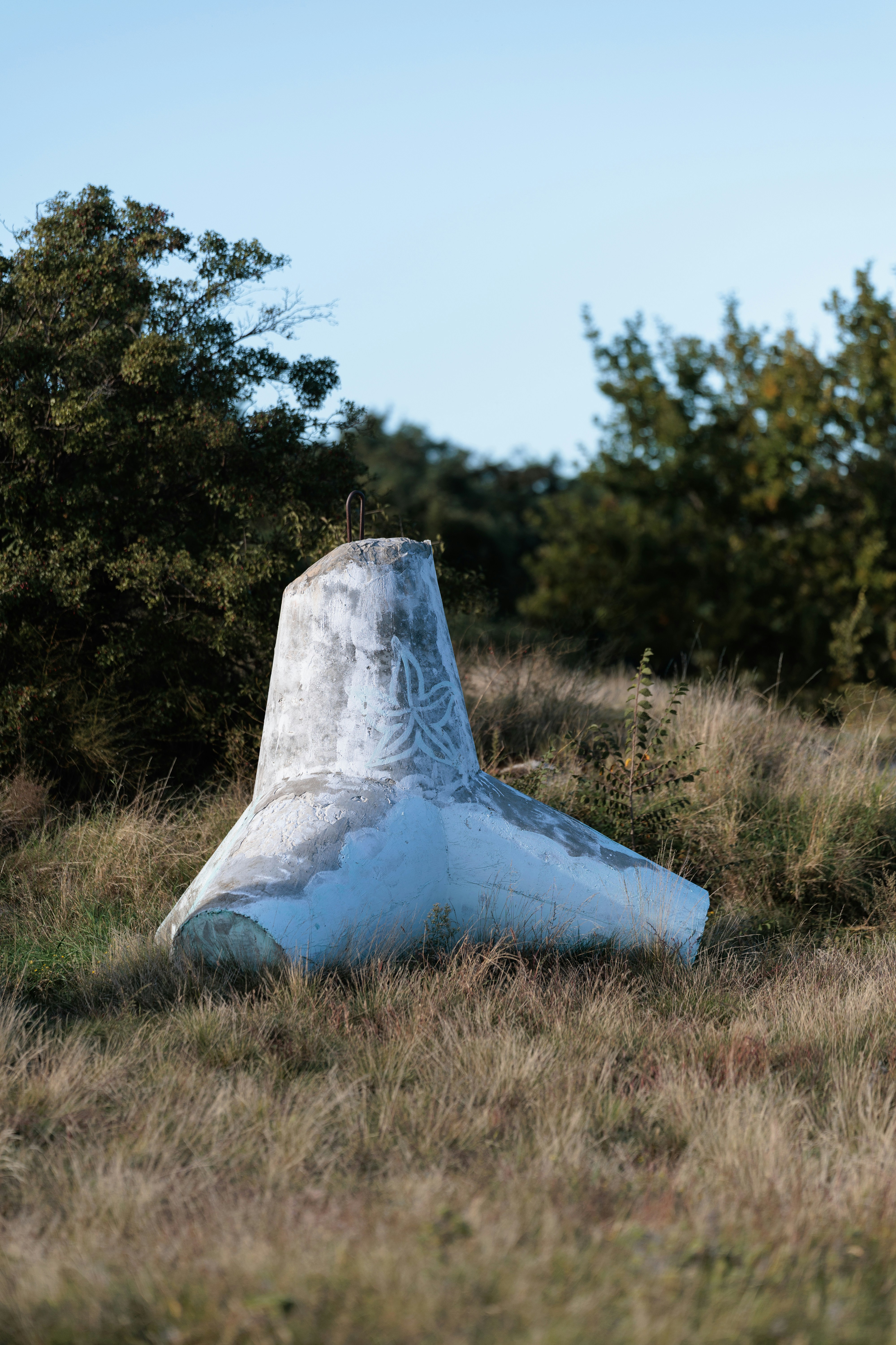 Weathered Aegean Turret: A Concrete Pillar Reclaimed by Grass