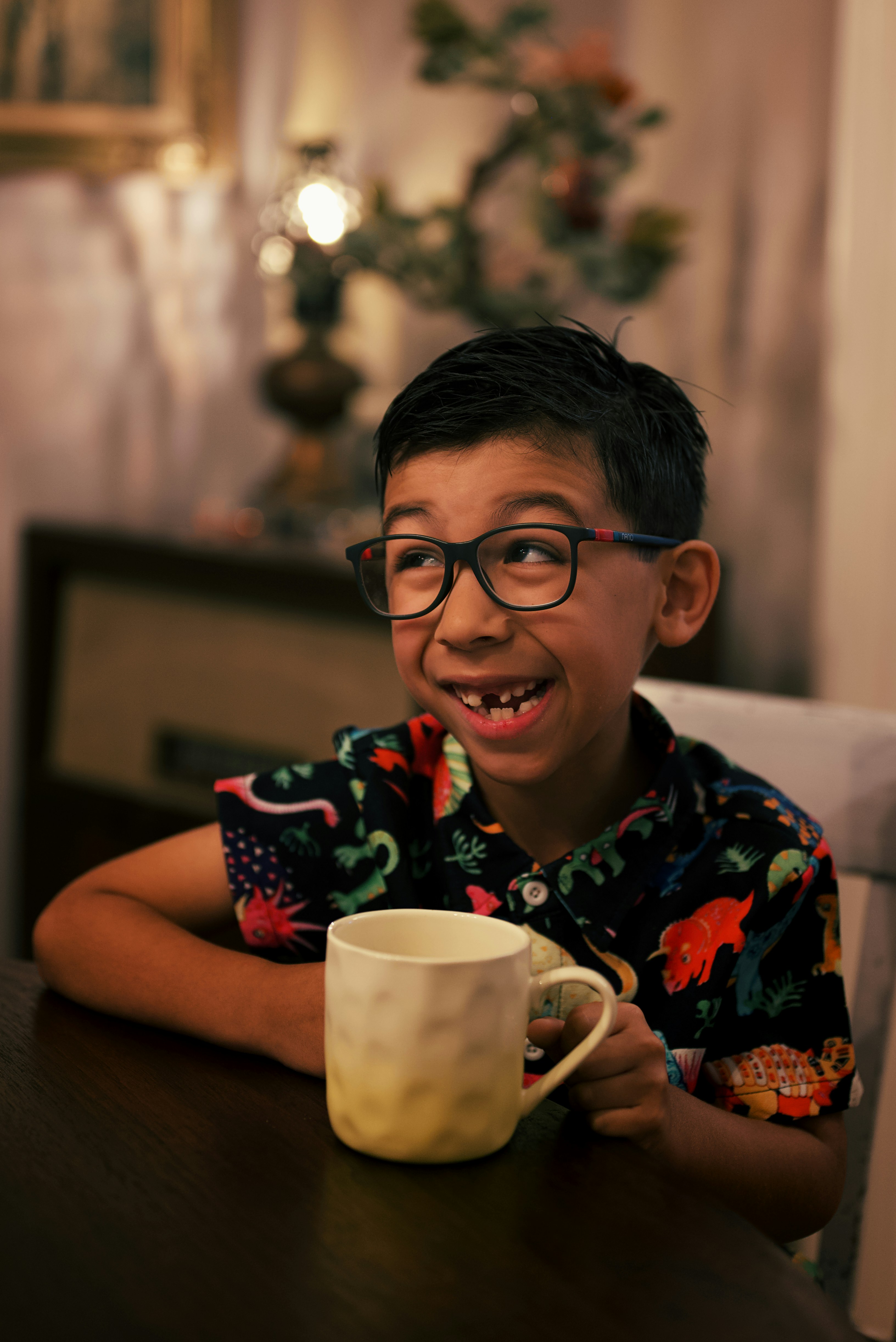 Curious Grin Over Coffee: A Portrait in Warm Indoor Light