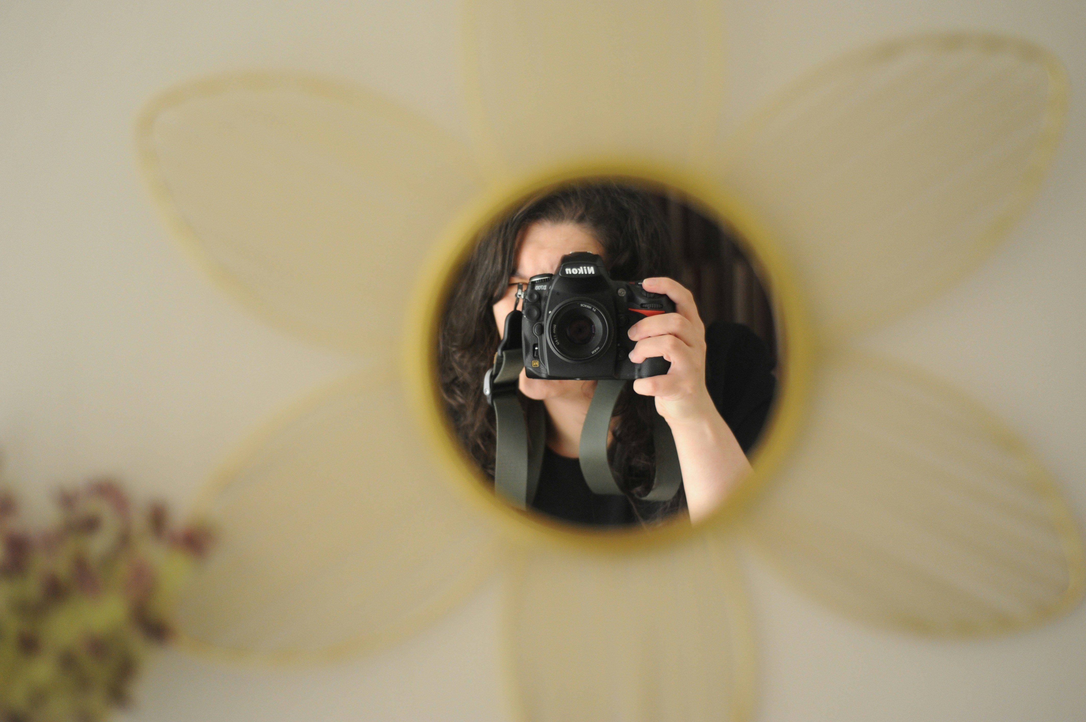 Behind the Lens: A Self-Portrait Framed by a Soft Yellow Bloom