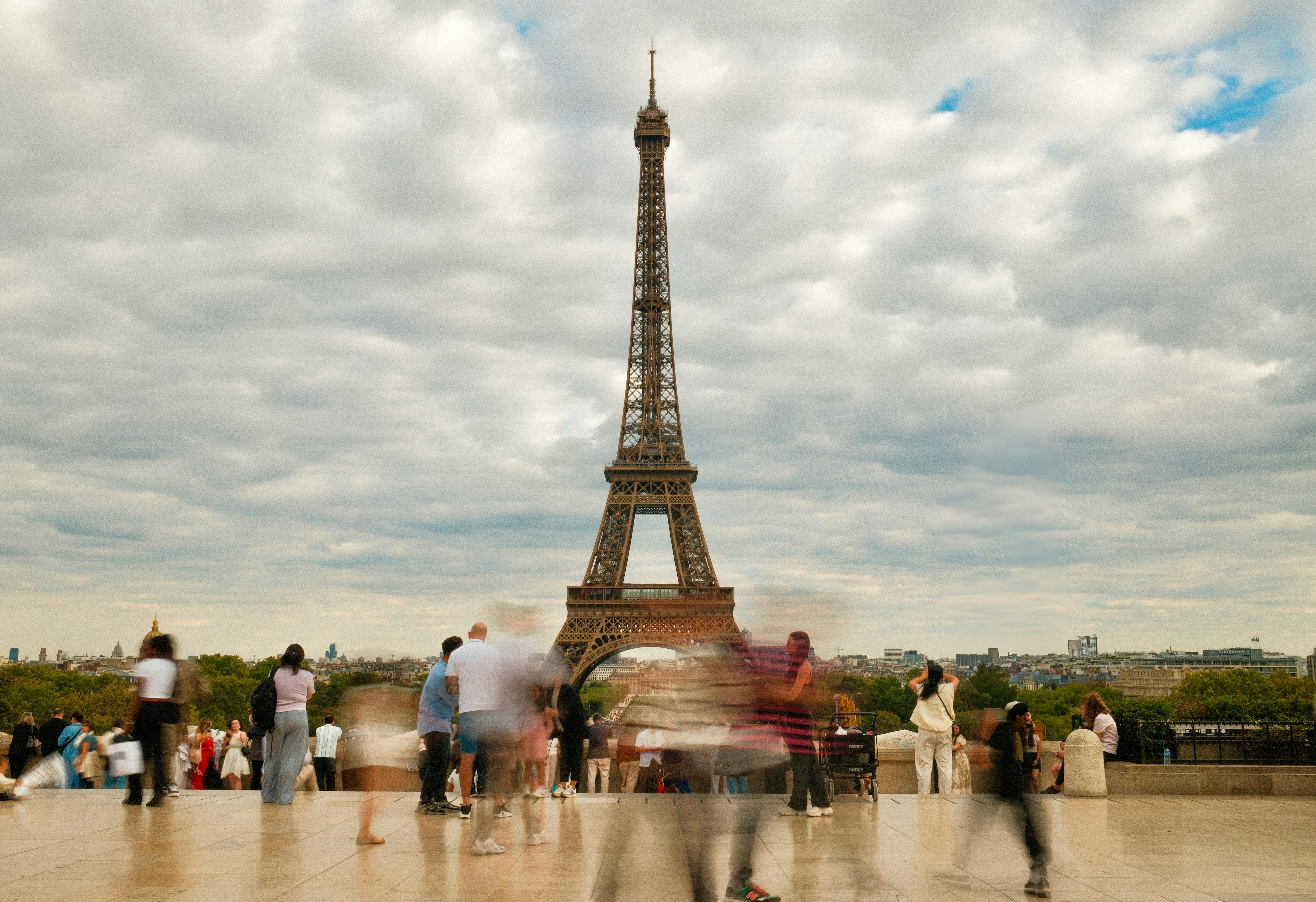Eiffel Tower Silhouette Beneath a Crowded Skywalk