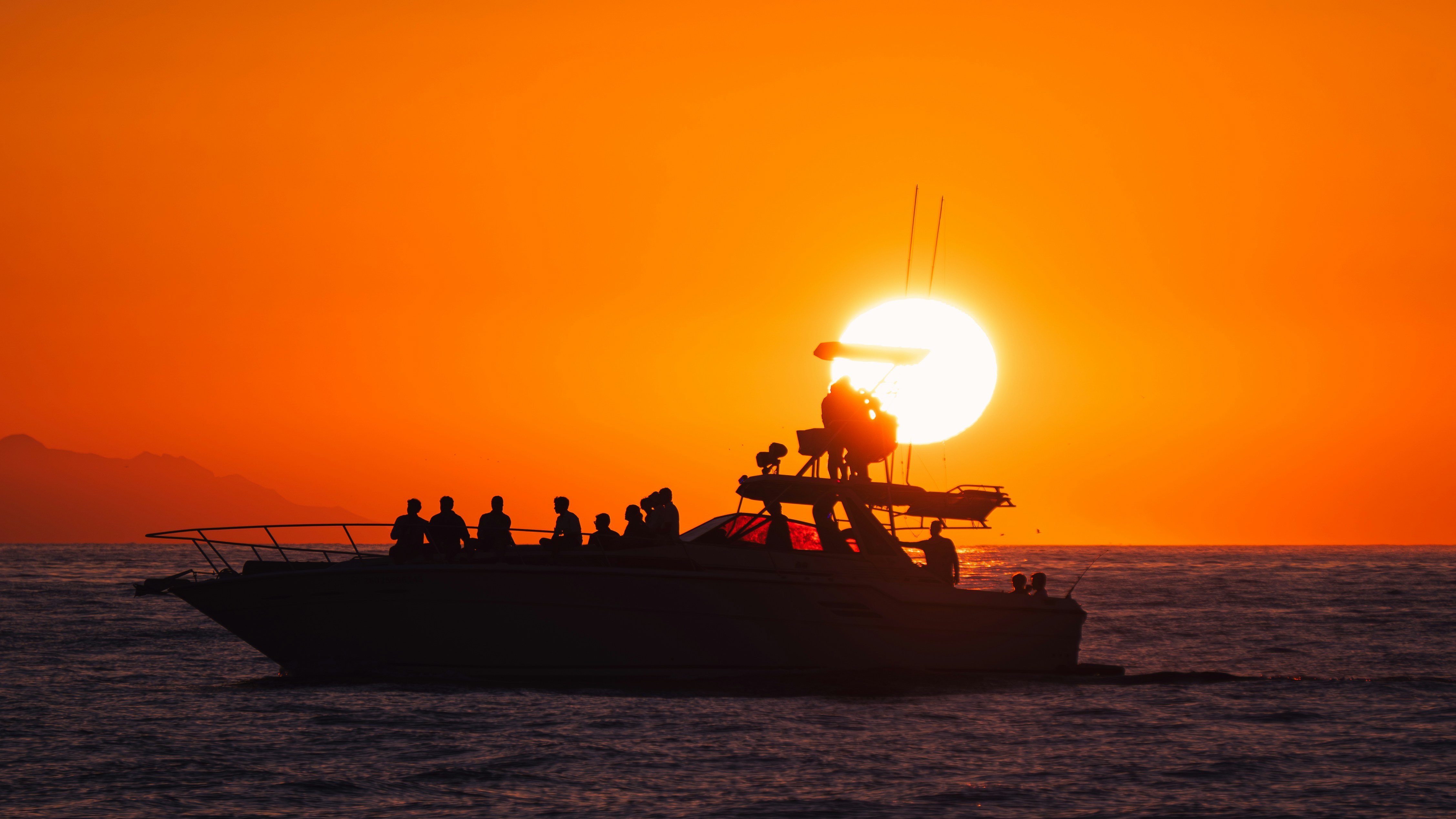 Sunlit Passage: A Boat Crossing the Glowing Horizon at Dusk