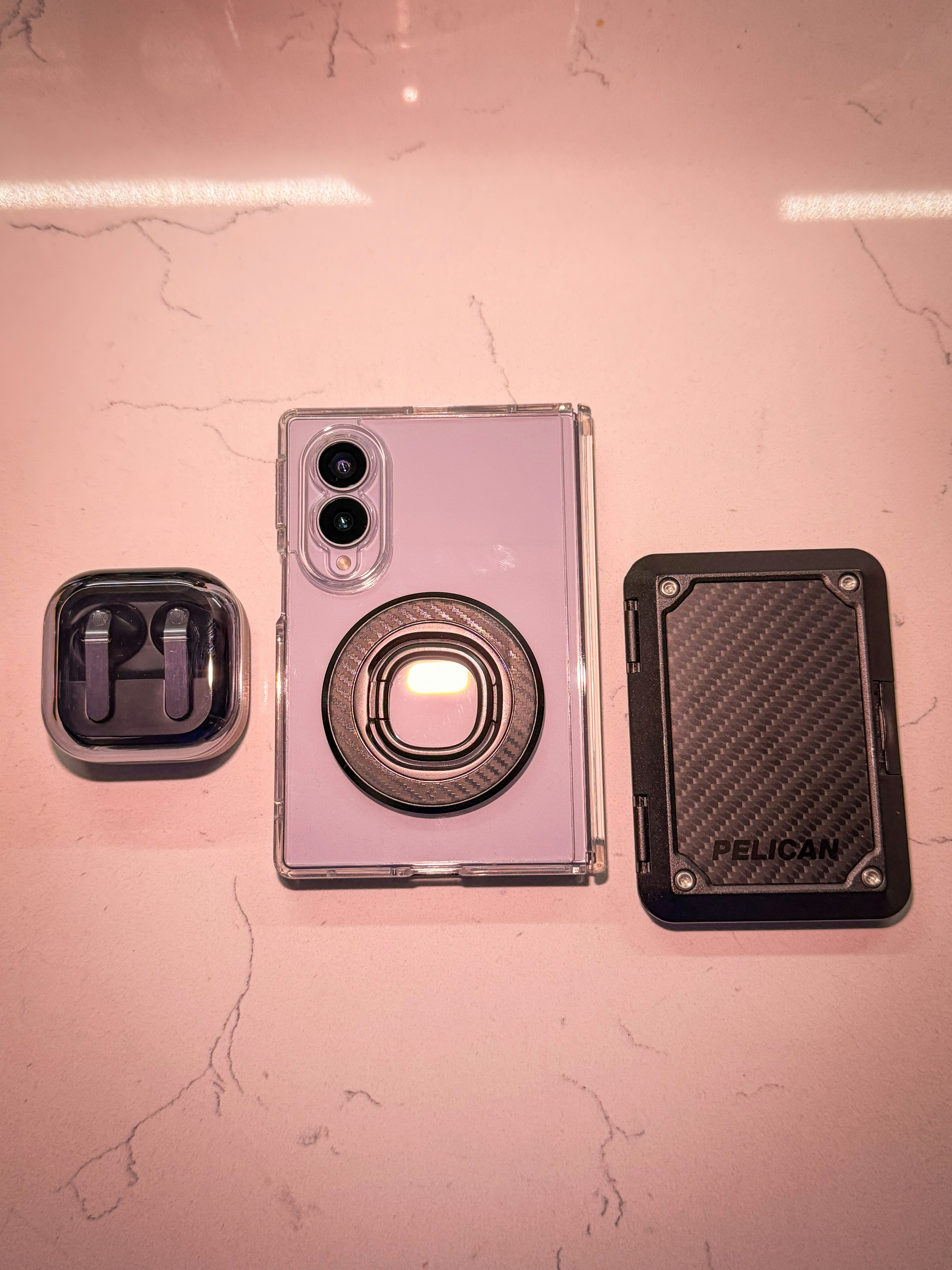 Essential Gear on a Marble Countertop: iPhone 14 Pro and Accessory Pack