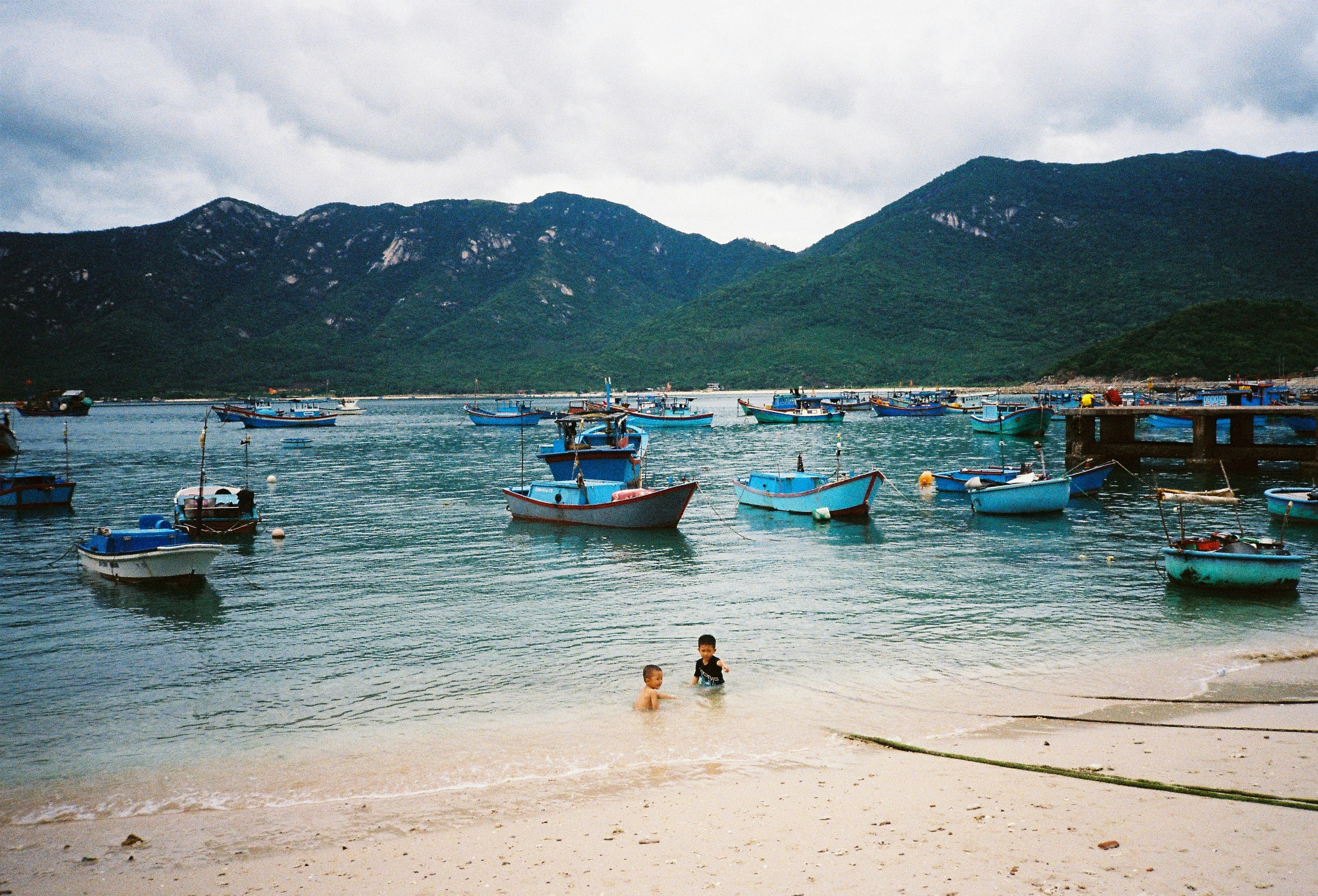 Shoreline Whispers: Boats at Rest and Children at Play