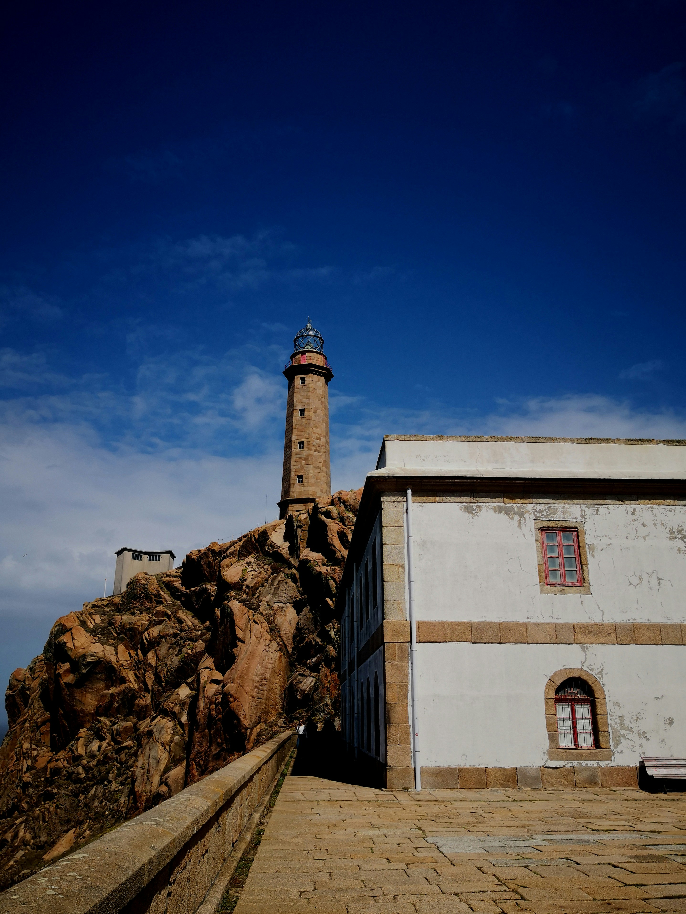 Lighthouse Sentinel on rugged Cape, Beside a Weathered Estate
