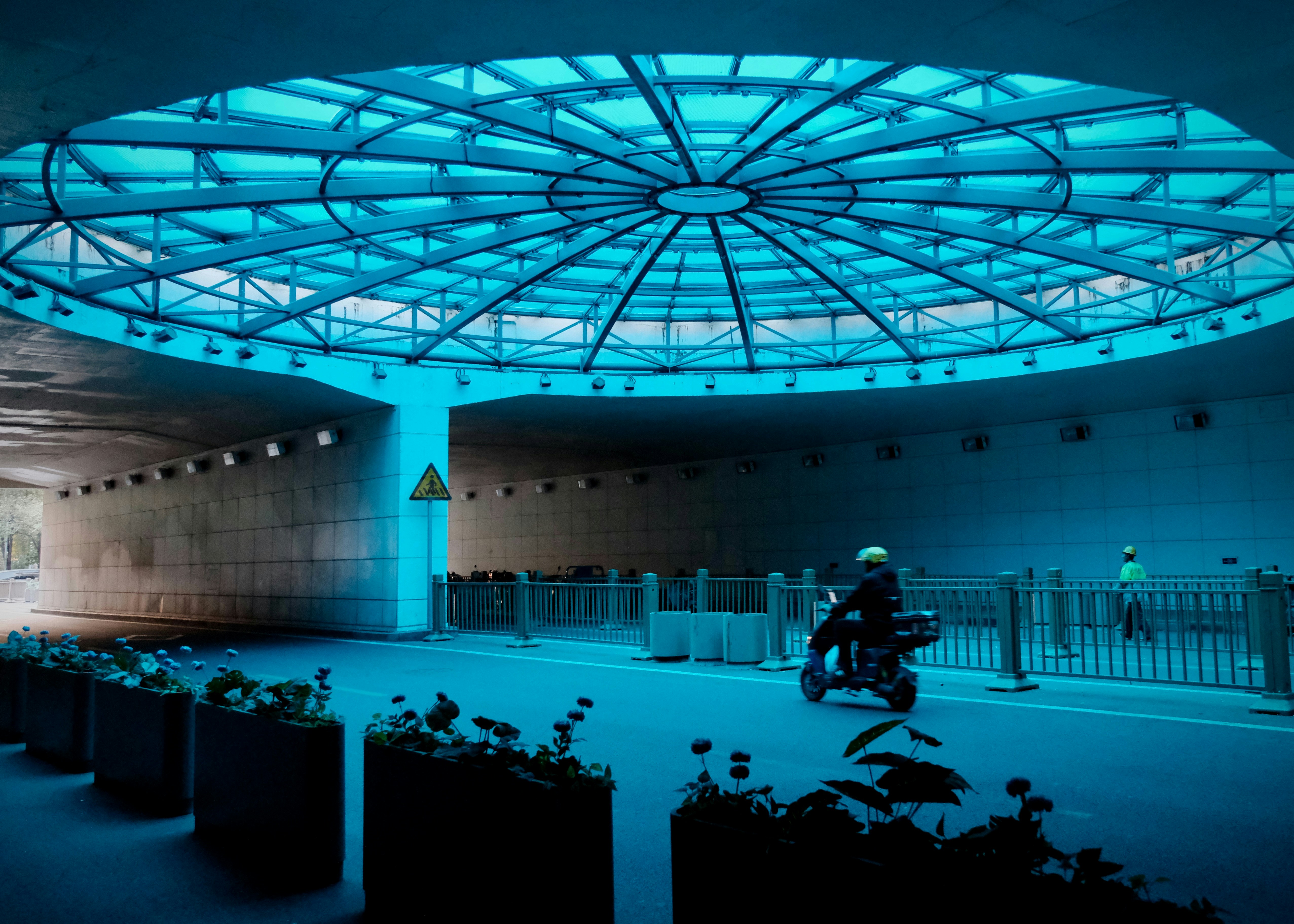 Blue Dome Walkway: A Lone Rider Under a Geometric Ceiling