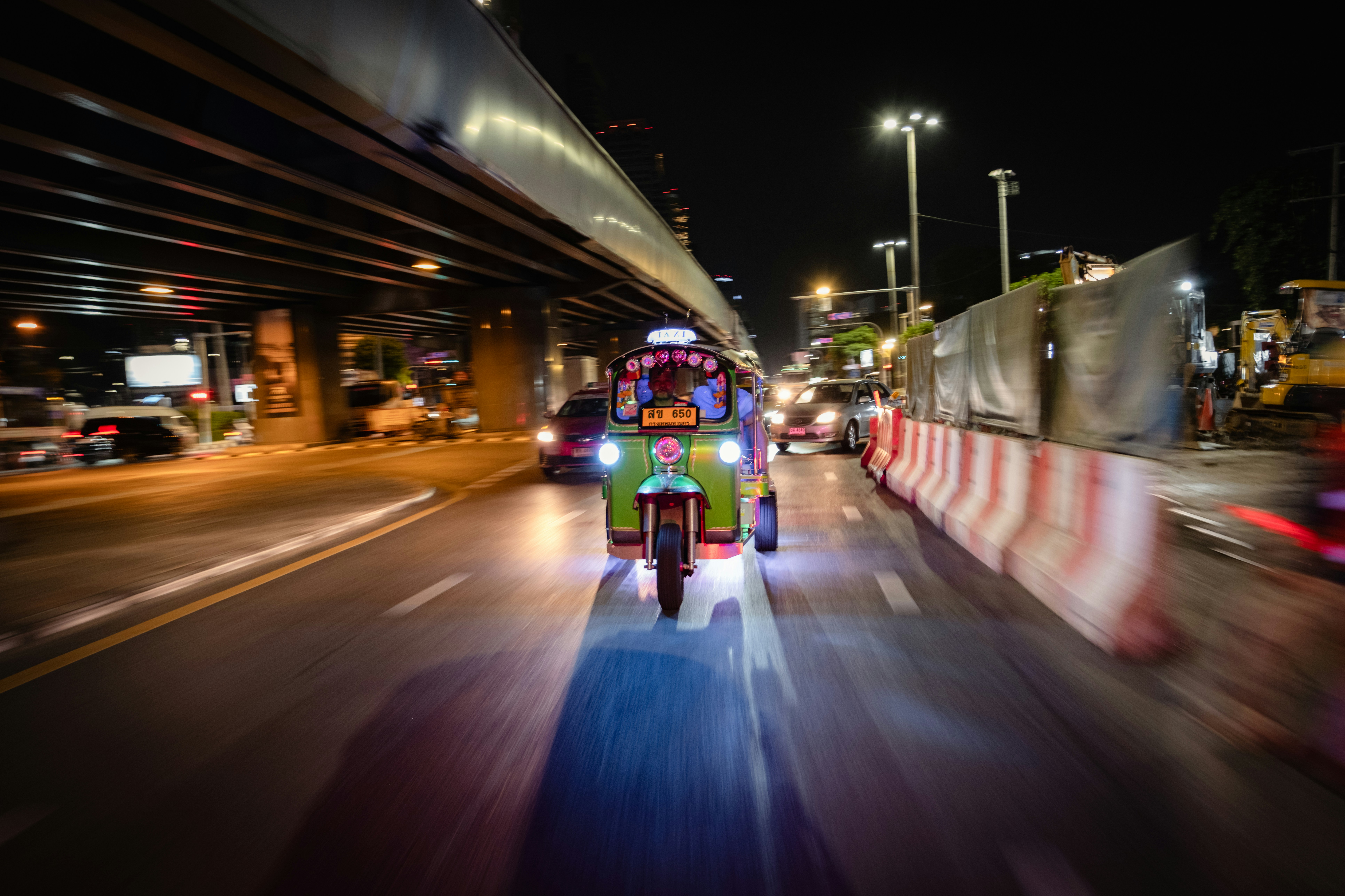 Night Ride Under the Overpass: A Neon-Tinted Auto Rickshaw in Motion