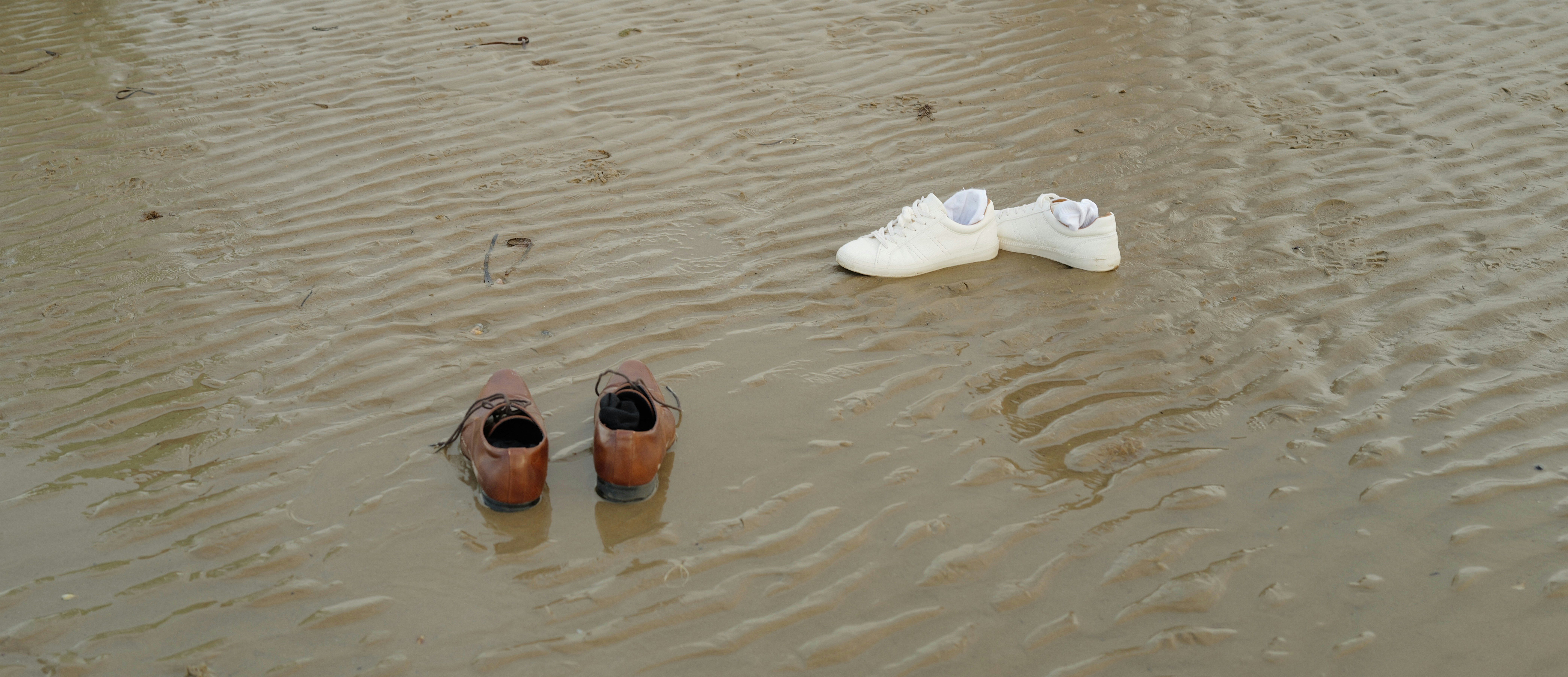 Floating Footwear on Tidal Sand: A Quiet Moment of Solitude