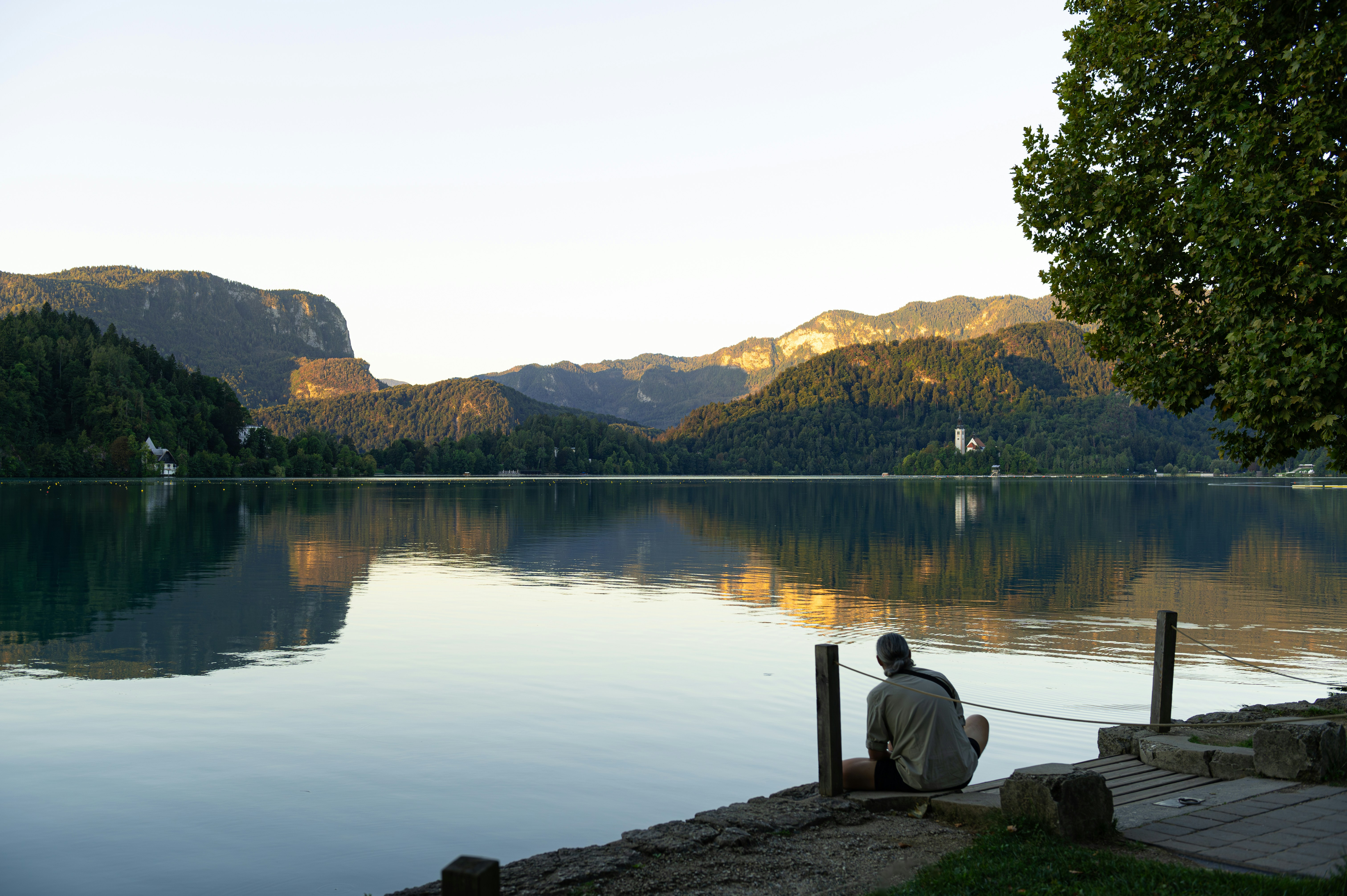 Quiet Lake Reflections: A Reclined Figure by the Distant Mountains